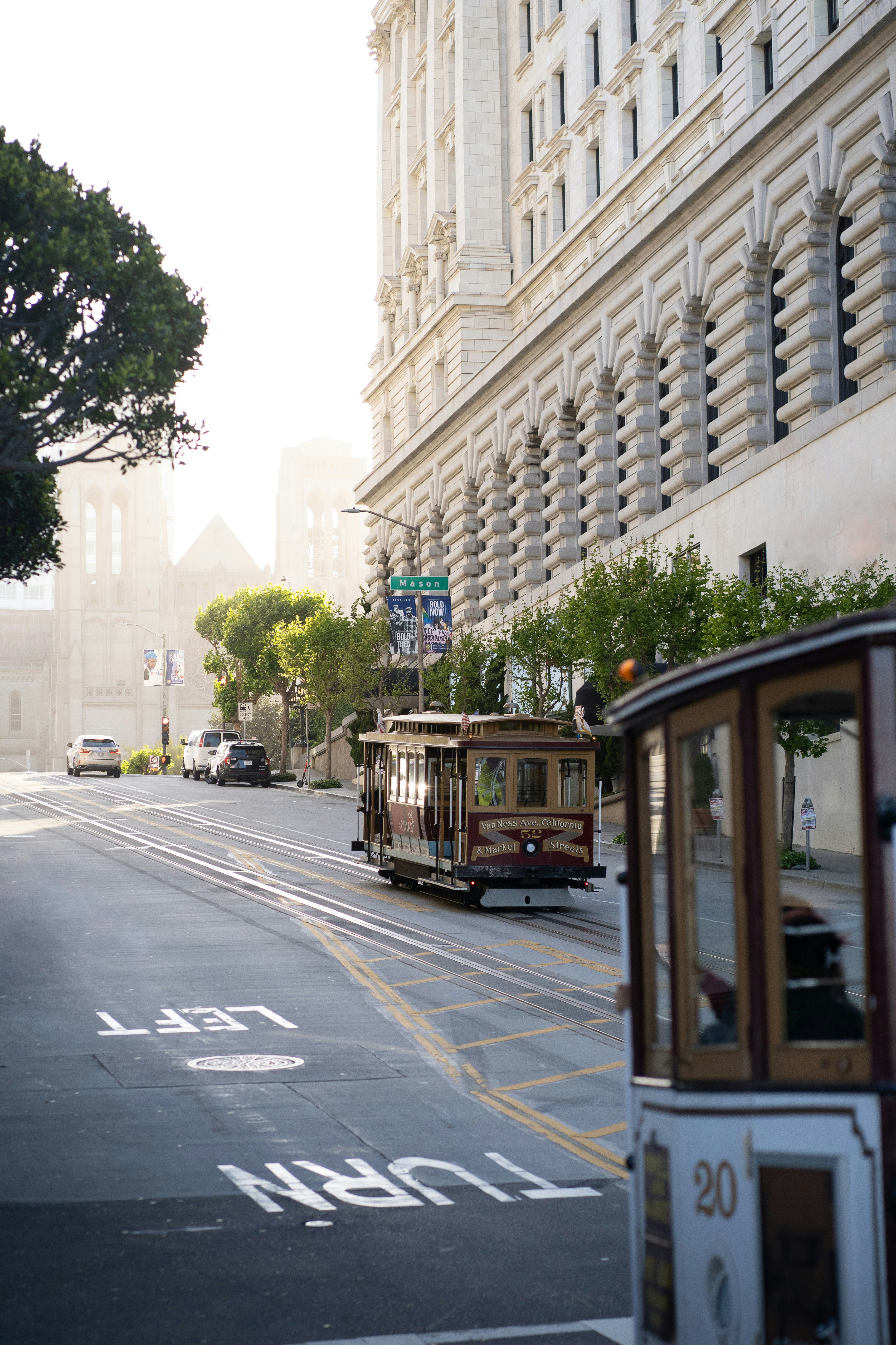 A trolley car driving down a street next to tall buildings photo – Free ...