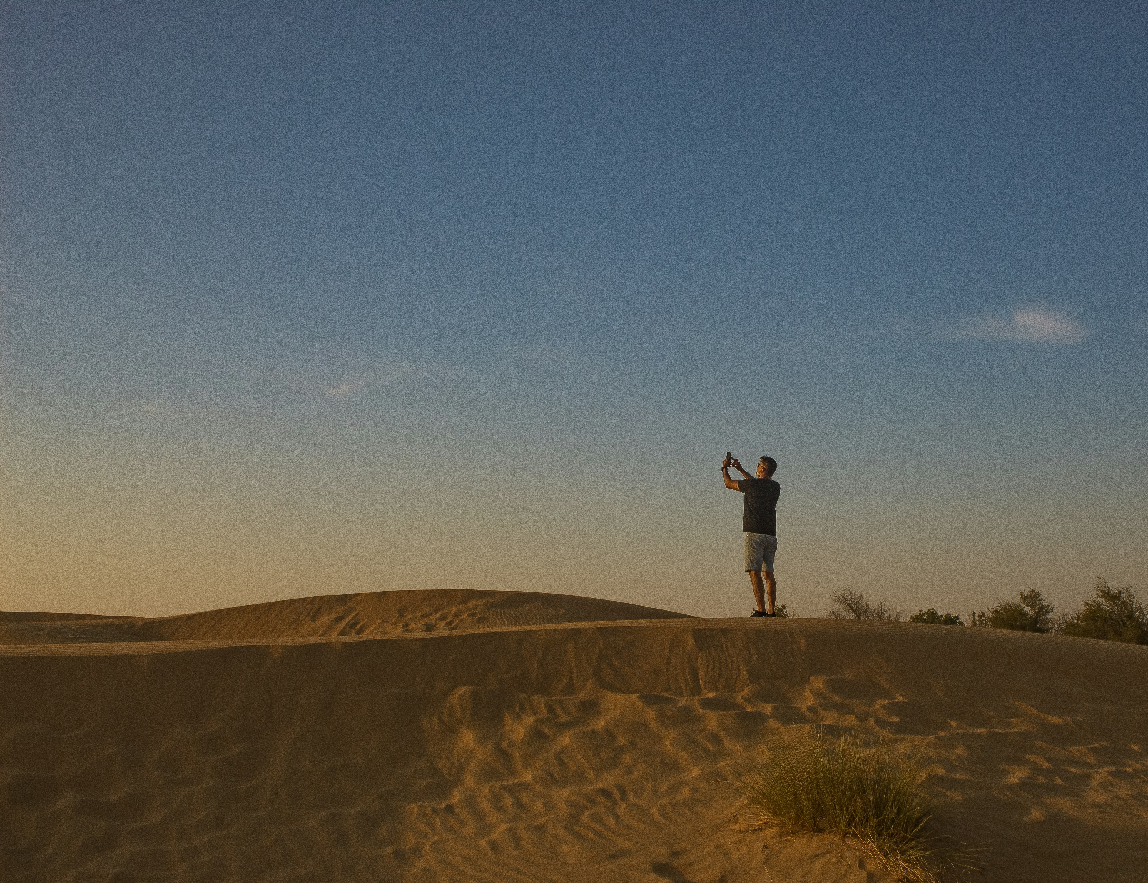 Lone Photographer on a Wind-Sculpted Dune at Golden Hour