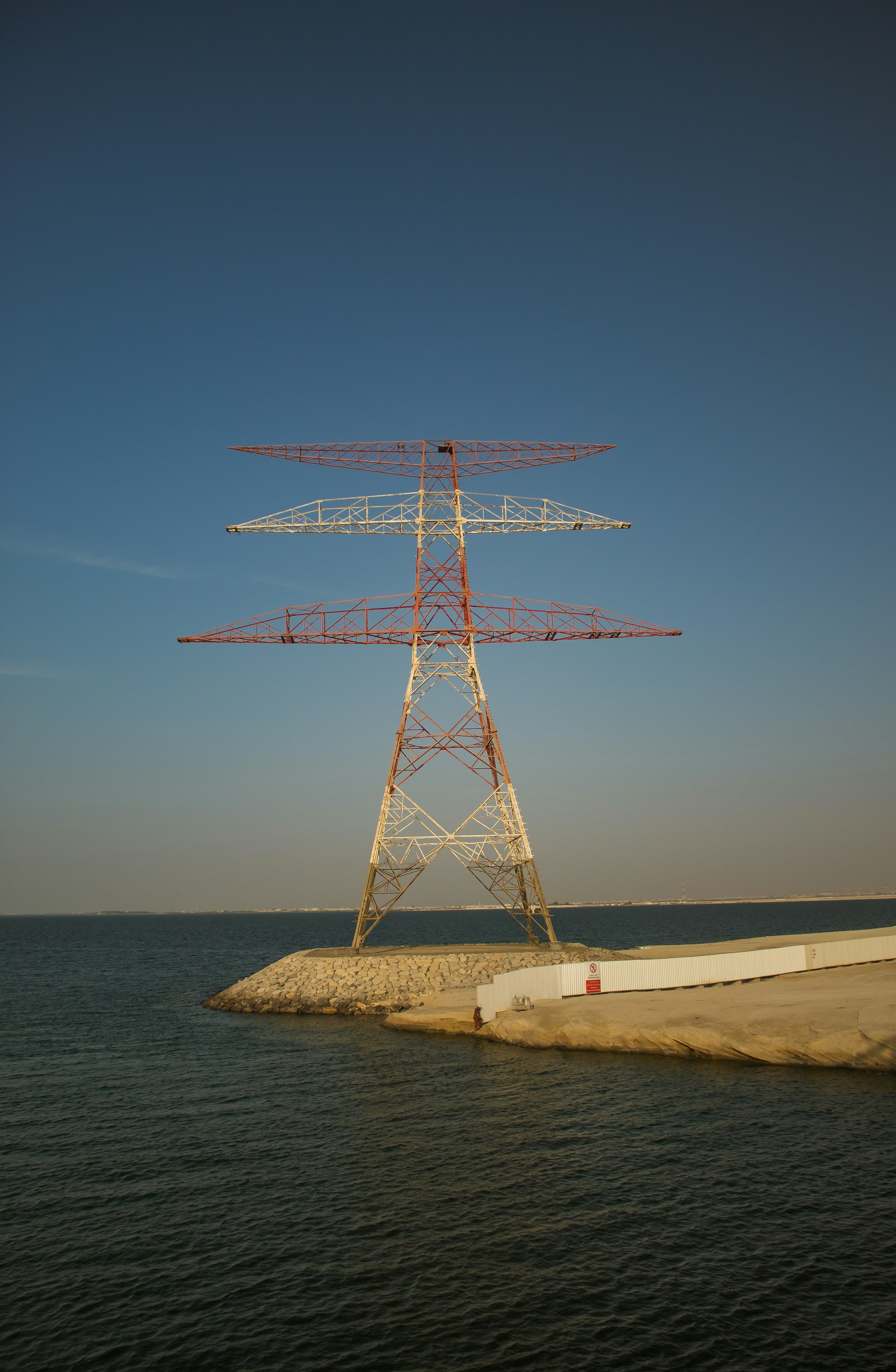 Harbor Lattice at Dusk: A Red-White Tower Guards the Breakwater