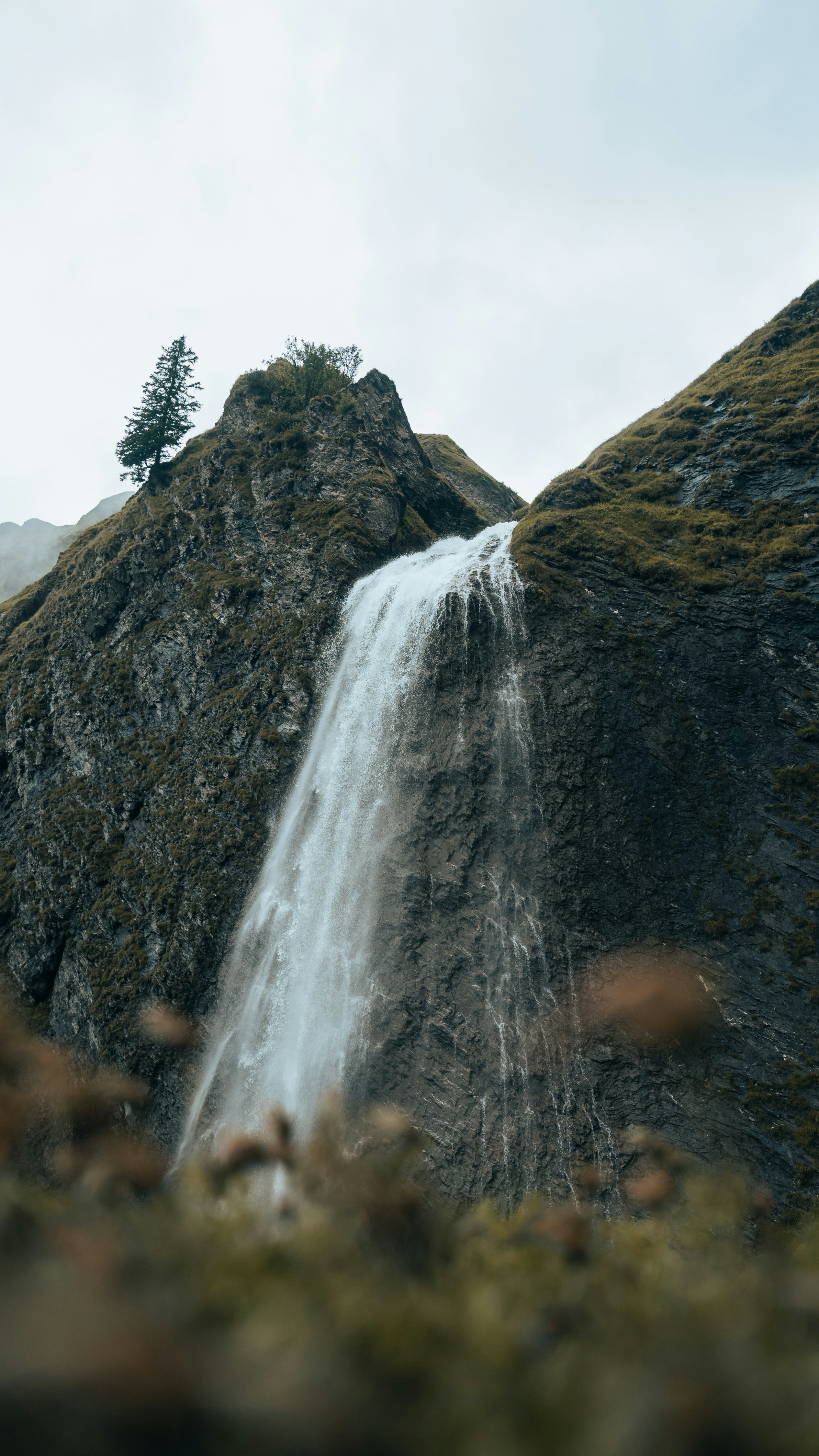 A small waterfall cascading down a mountain side photo – Free ...