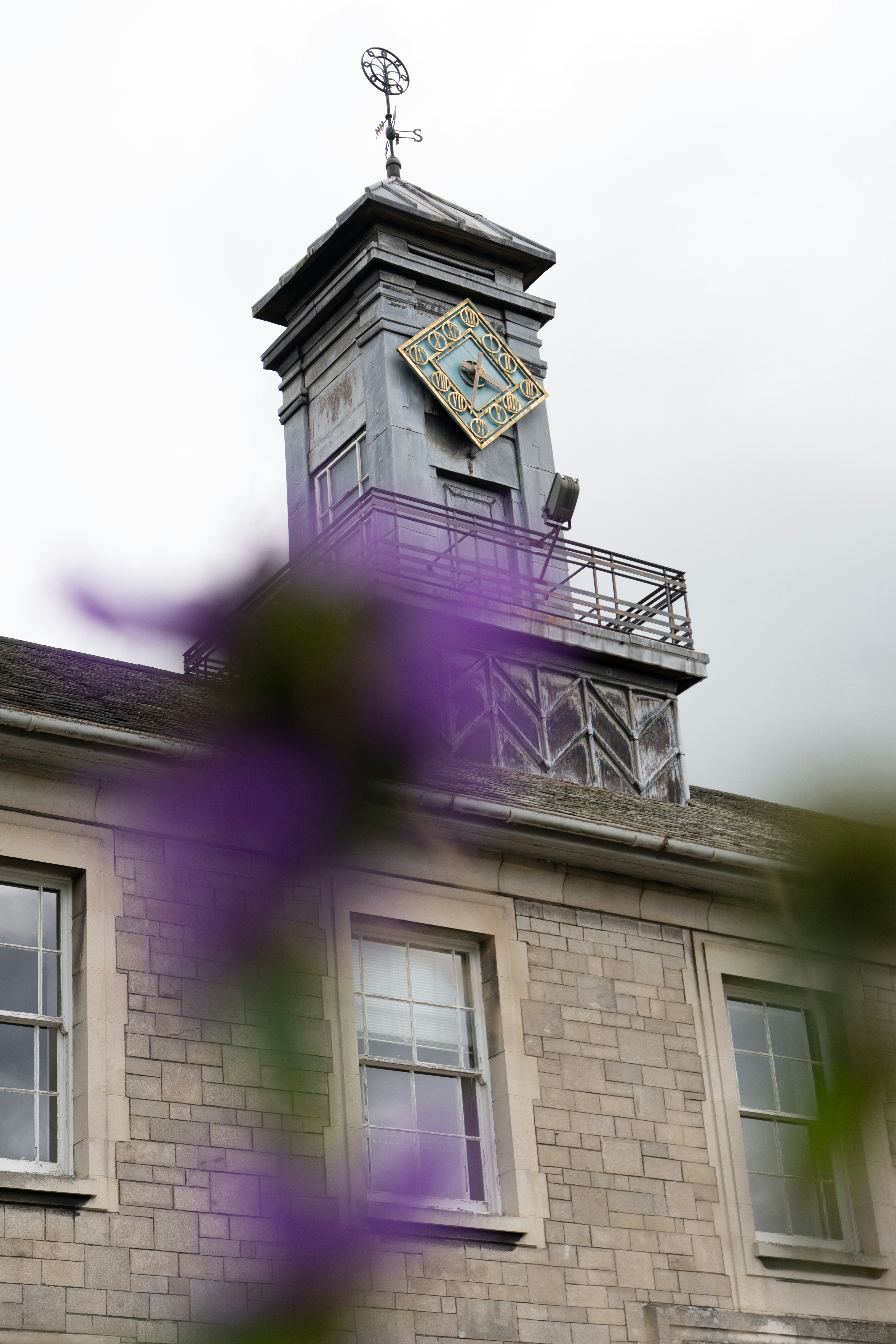 Clocktower Crowned by Violet Veil Over a Historic Facade
