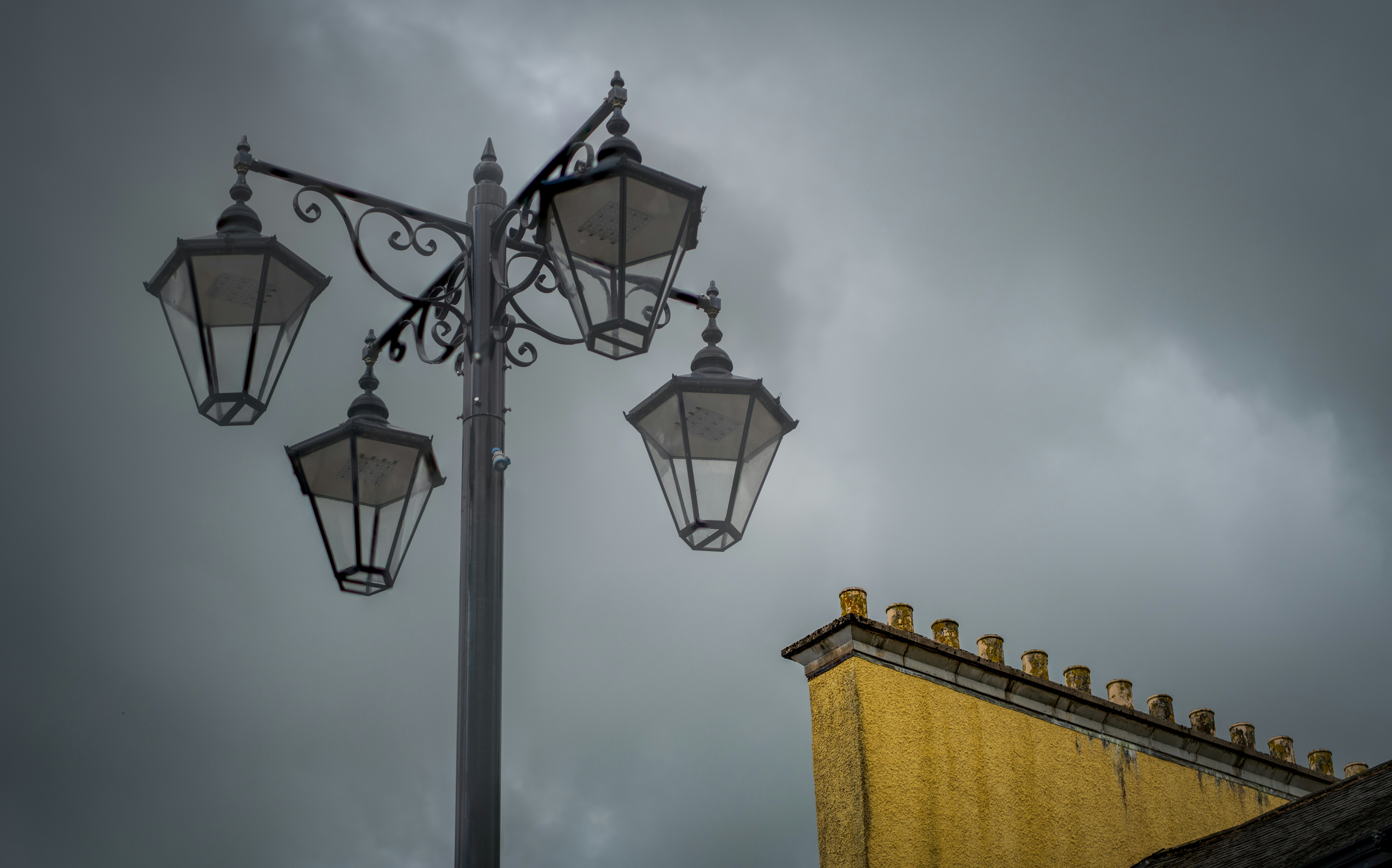 Gaslamp Quintet Against a Storm-Gray Sky Beside a Golden Corner