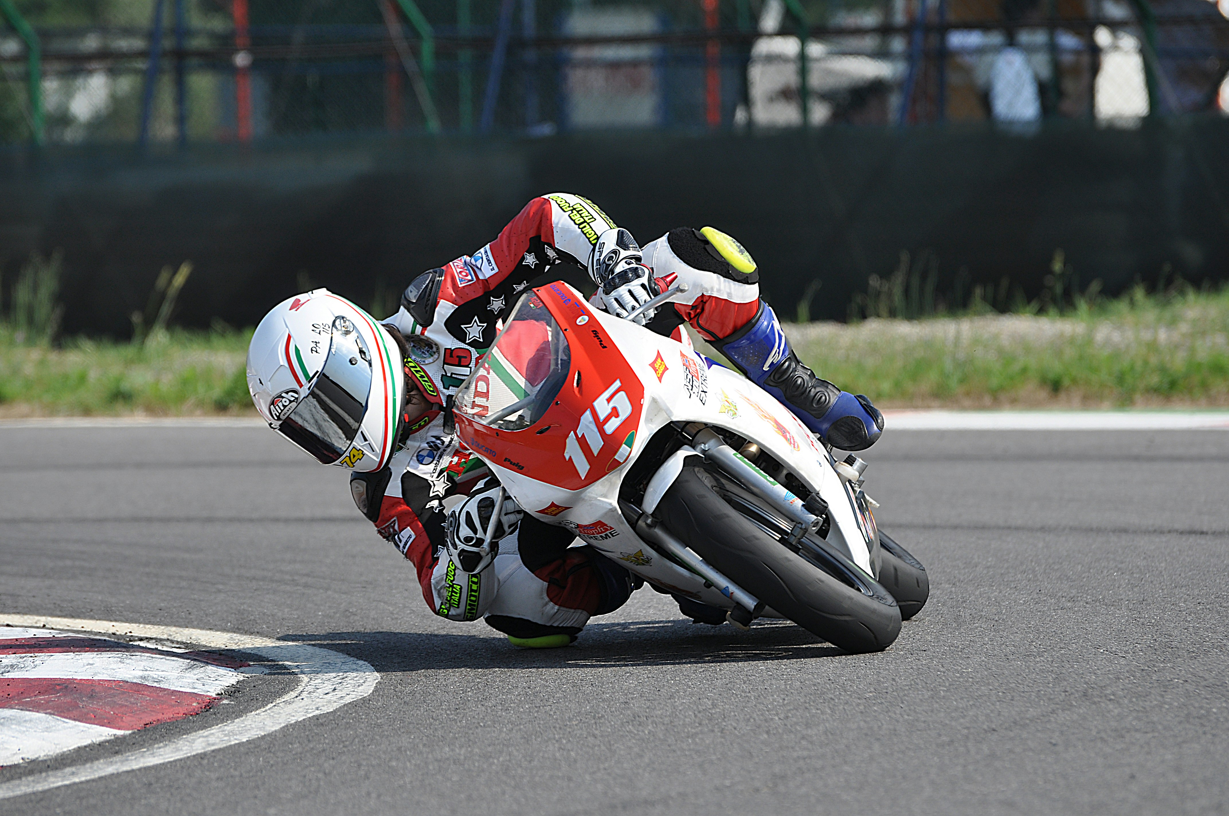 A person riding a motorcycle on a race track photo – Free Ragazzo Image ...