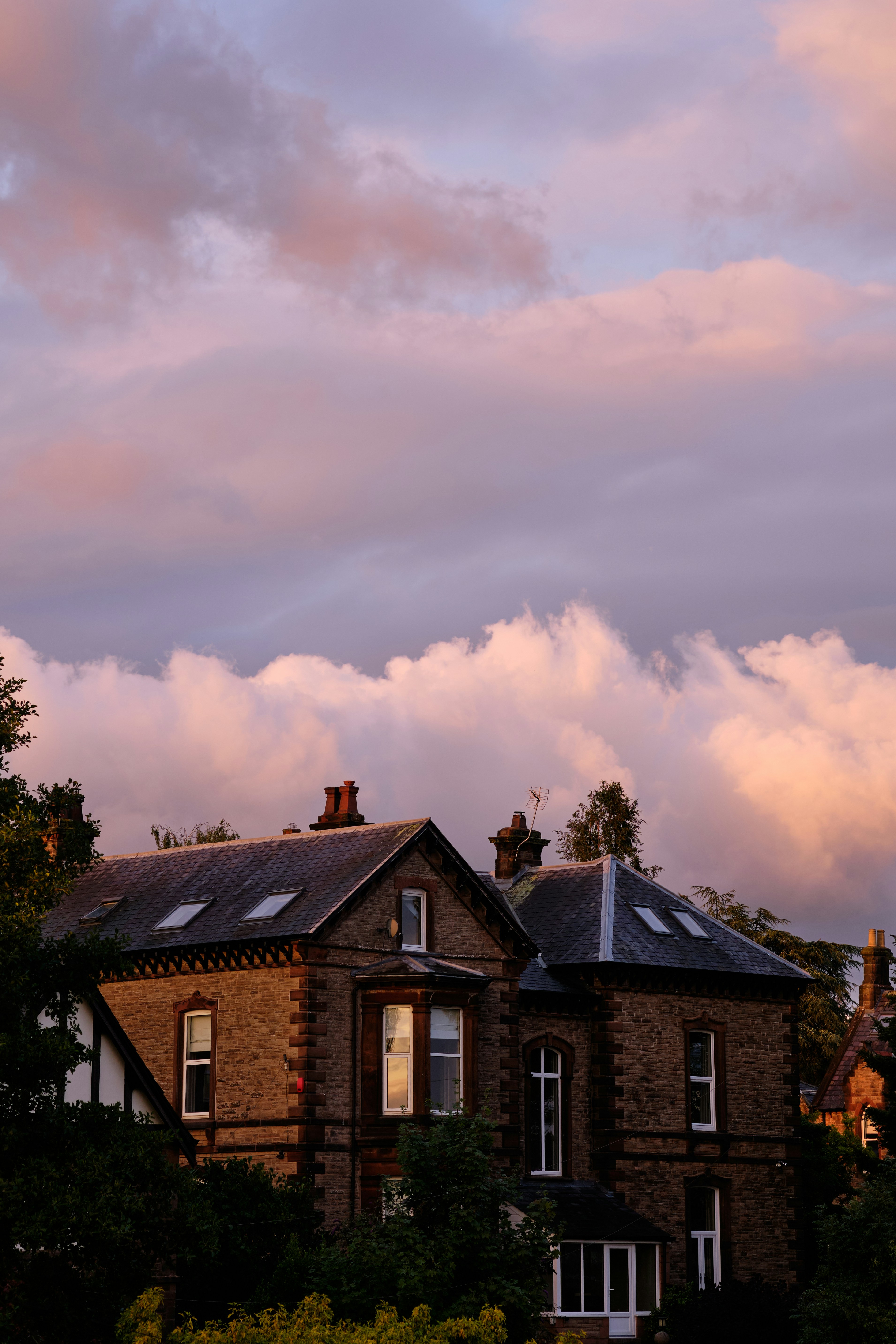 Twilight Rooftops: Brick Facades Against a Pink-Cloud Sky