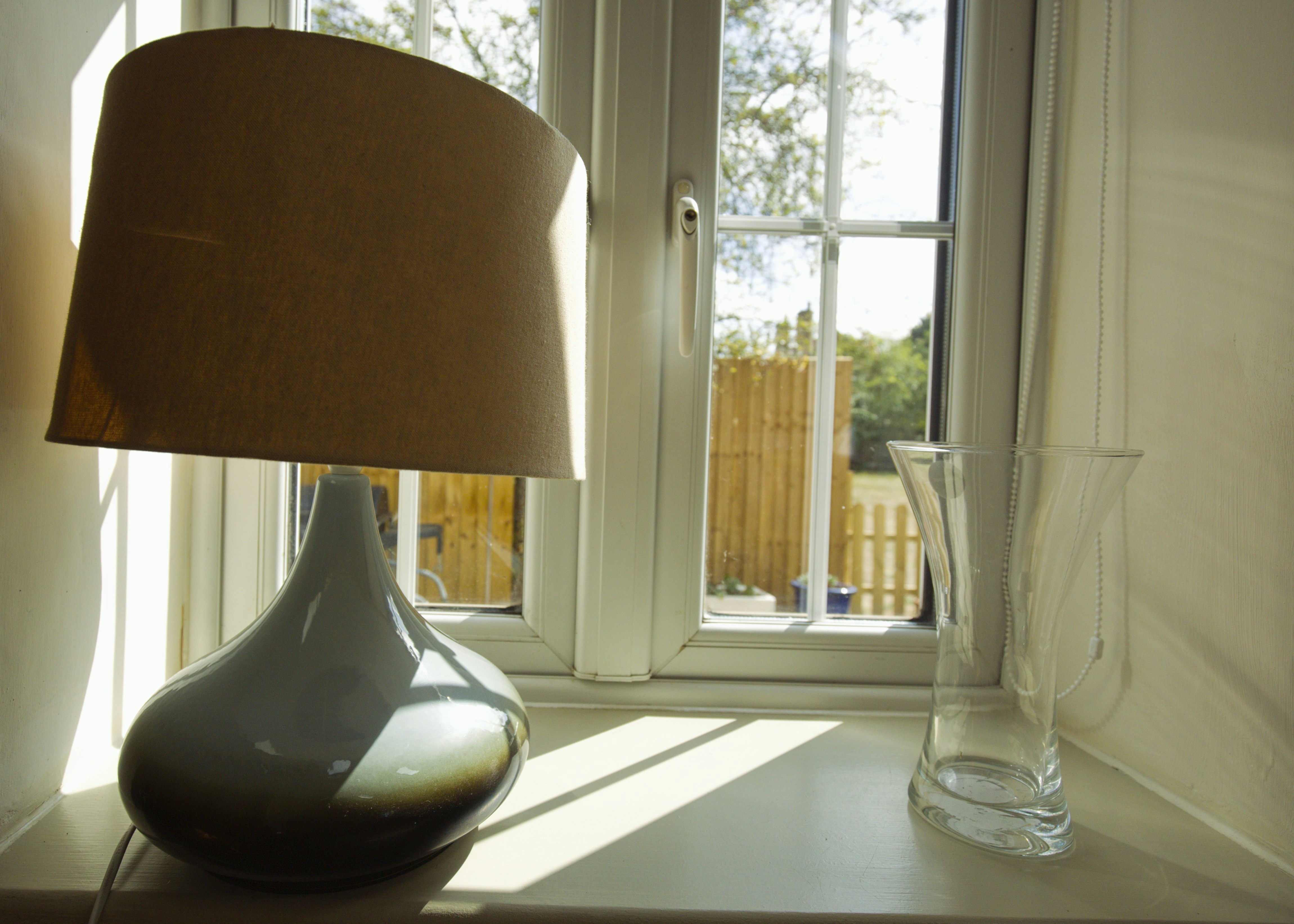 Morning Glow on a Quiet Window Sill: A Ceramic Lamp and a Glass Carafe
