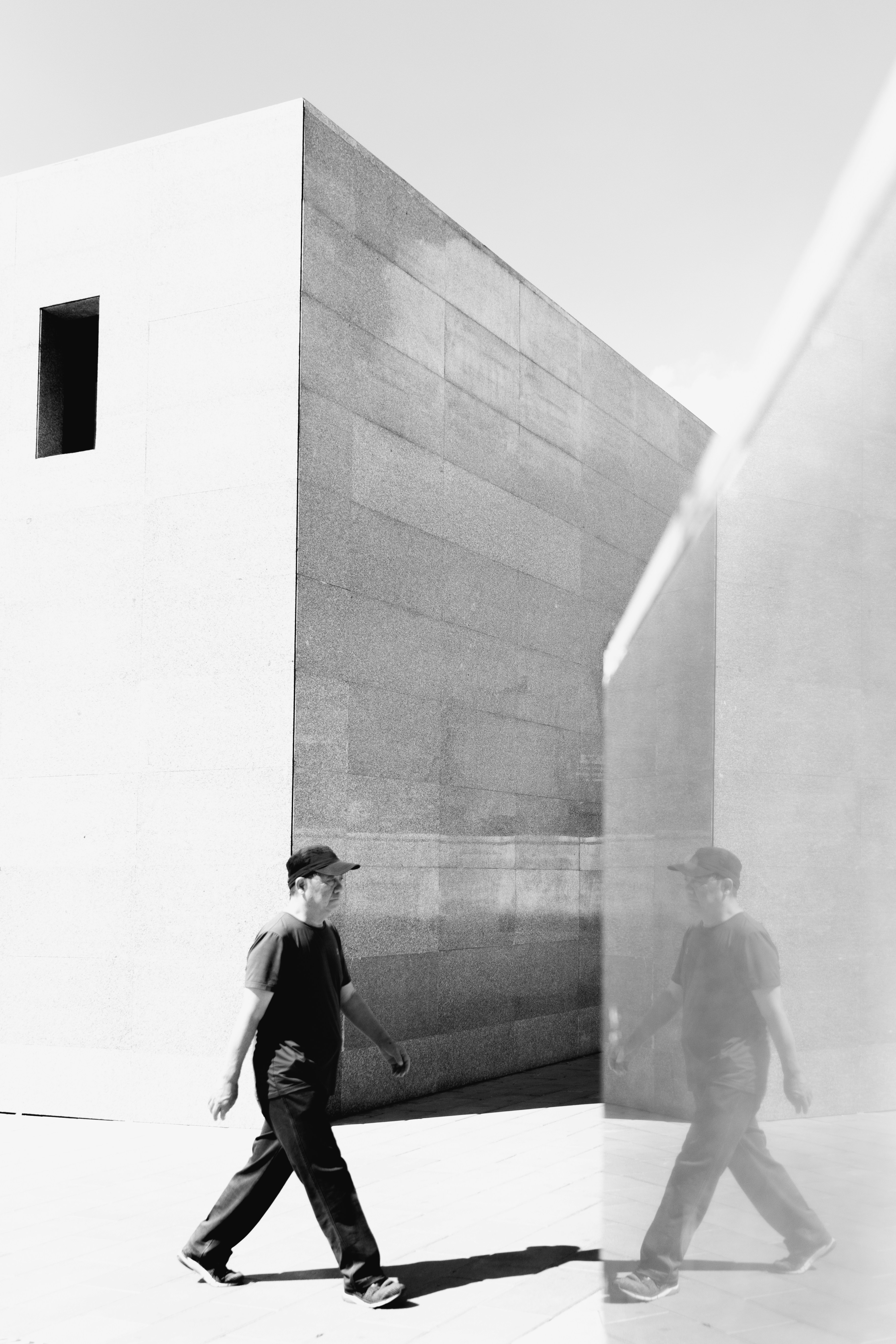 A couple of men walking past a tall building photo – Free Street ...