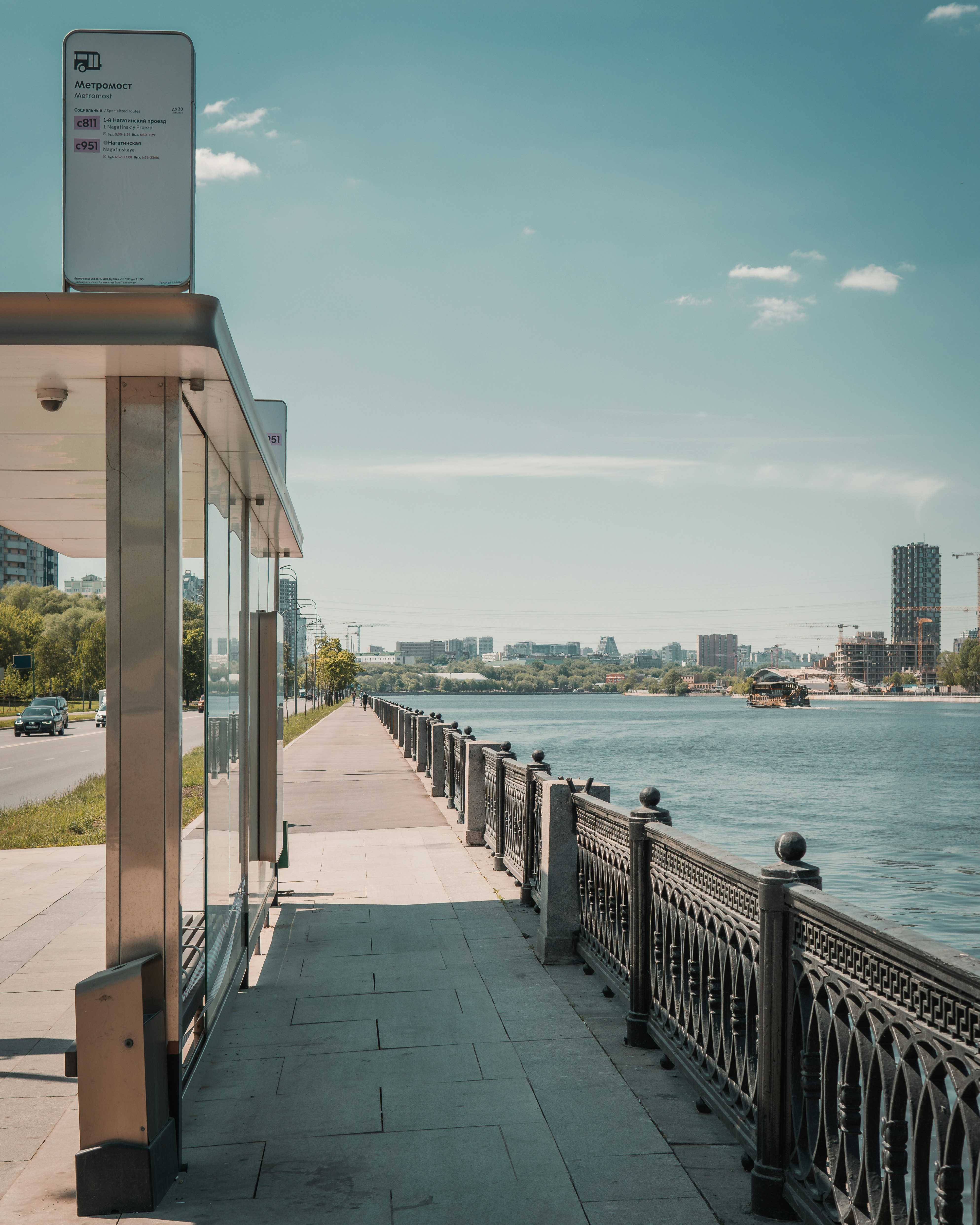 Waterfront Pathway: Railings, River, and Distant City