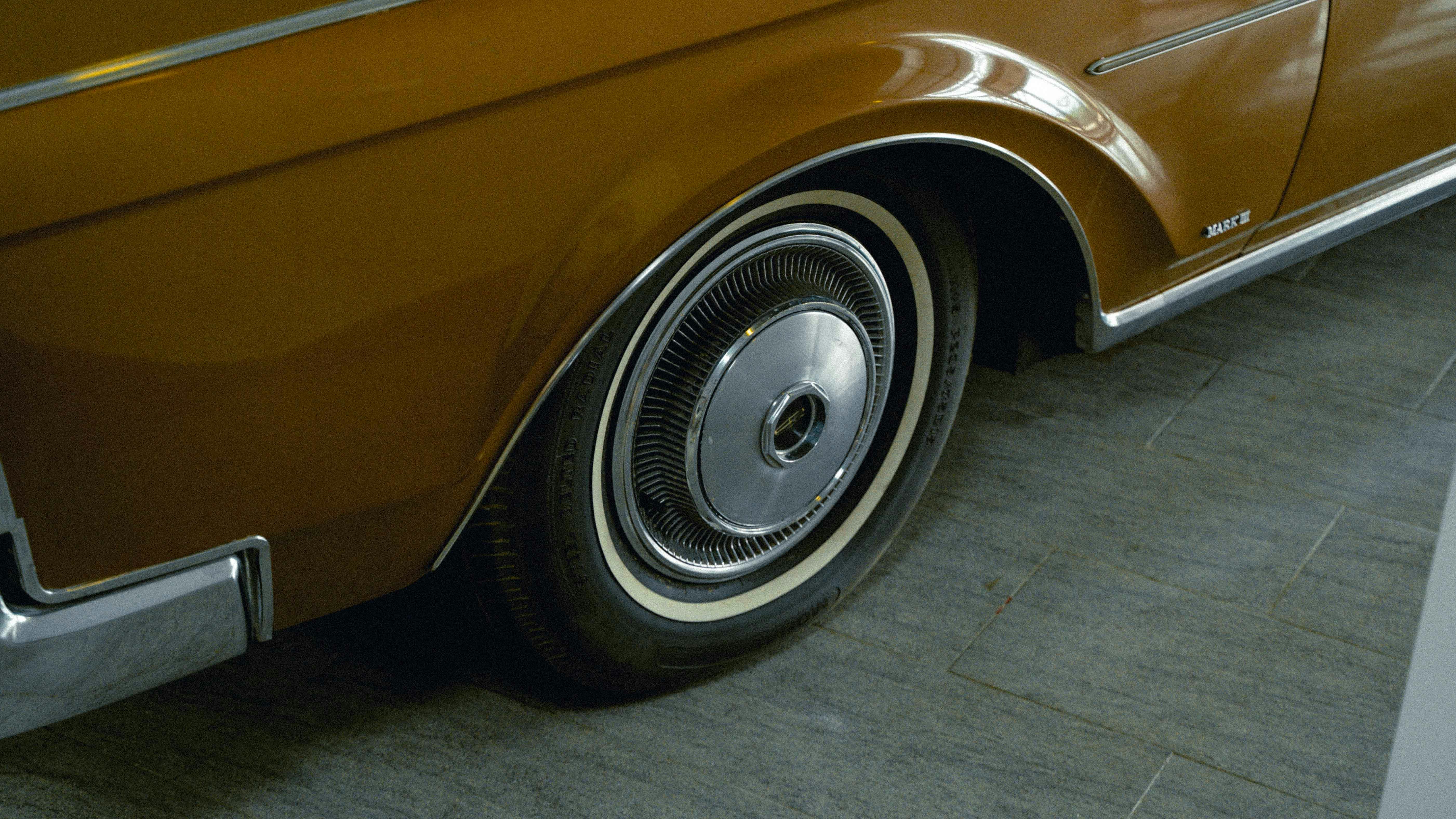 Amber Chrome: A Classic Car Corner with Shiny Wheel Emblem