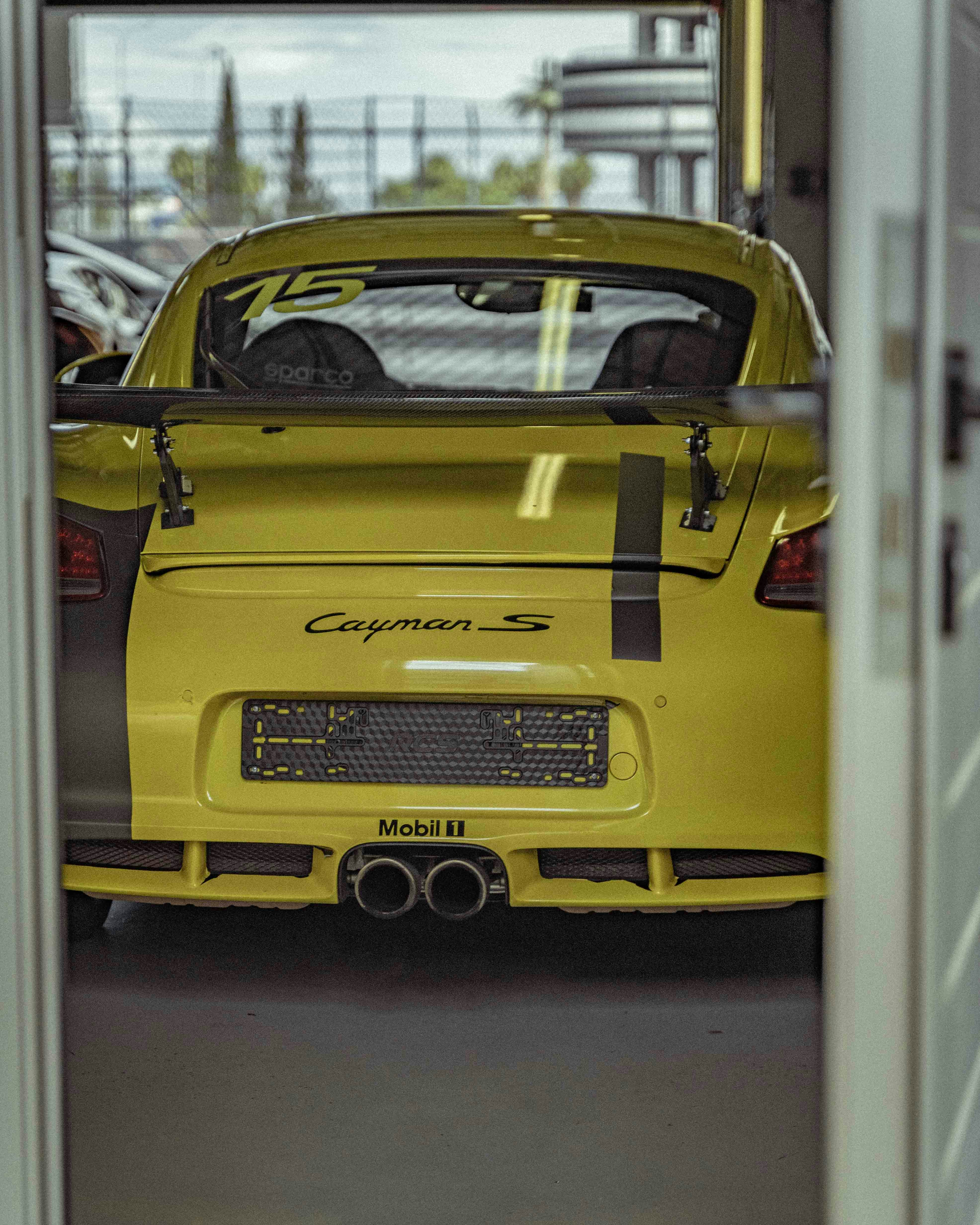 Yellow Cayman S in a Garage: Rear View with Race Heritage