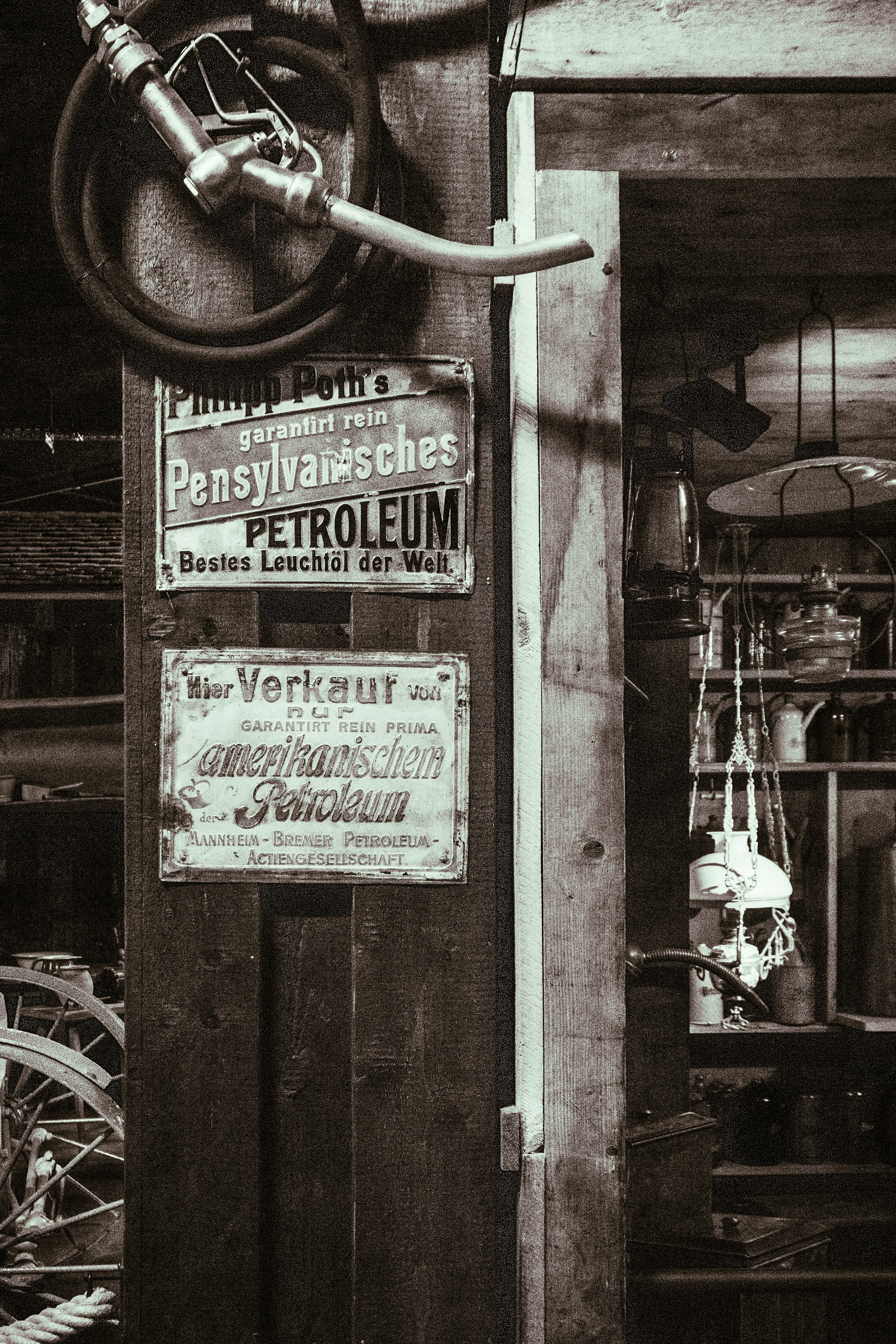 Rust and Radiance: Vintage Petroleum Signs Nestled in a Dim Workshop