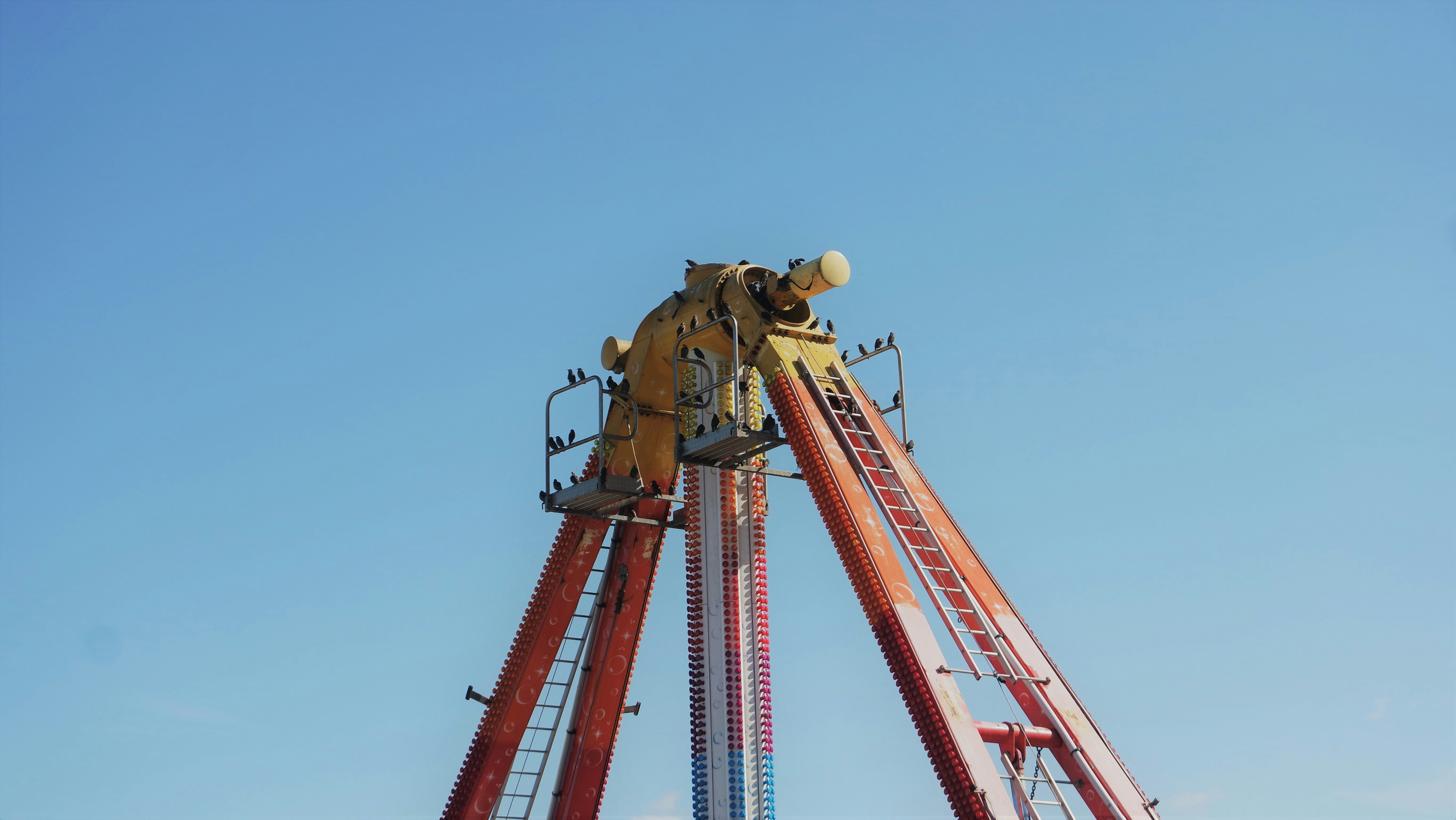 Crimson Lattice of a Towering Ride Against a Clear Sky