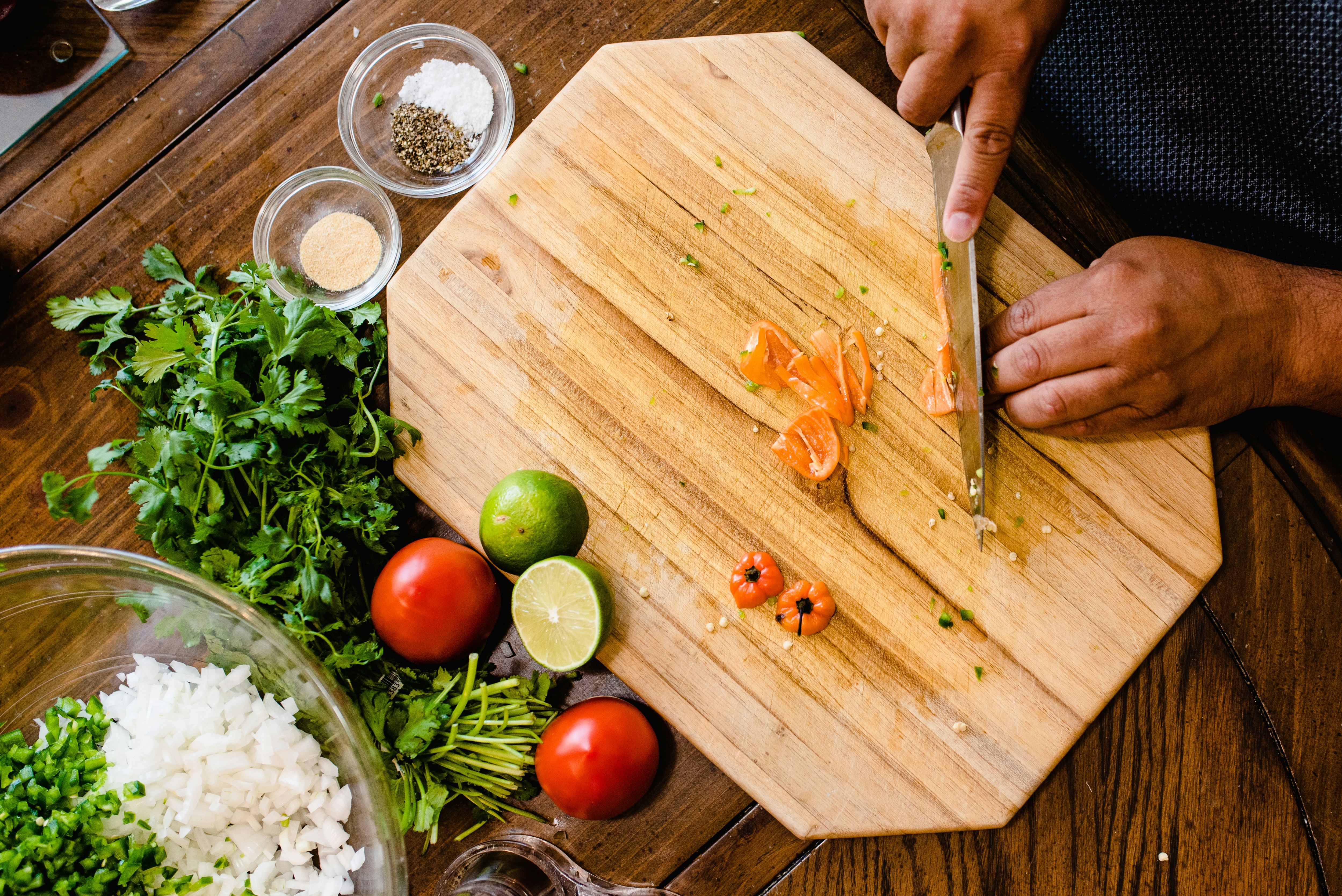 A person cutting up food on a cutting board photo – Free Food Image on ...