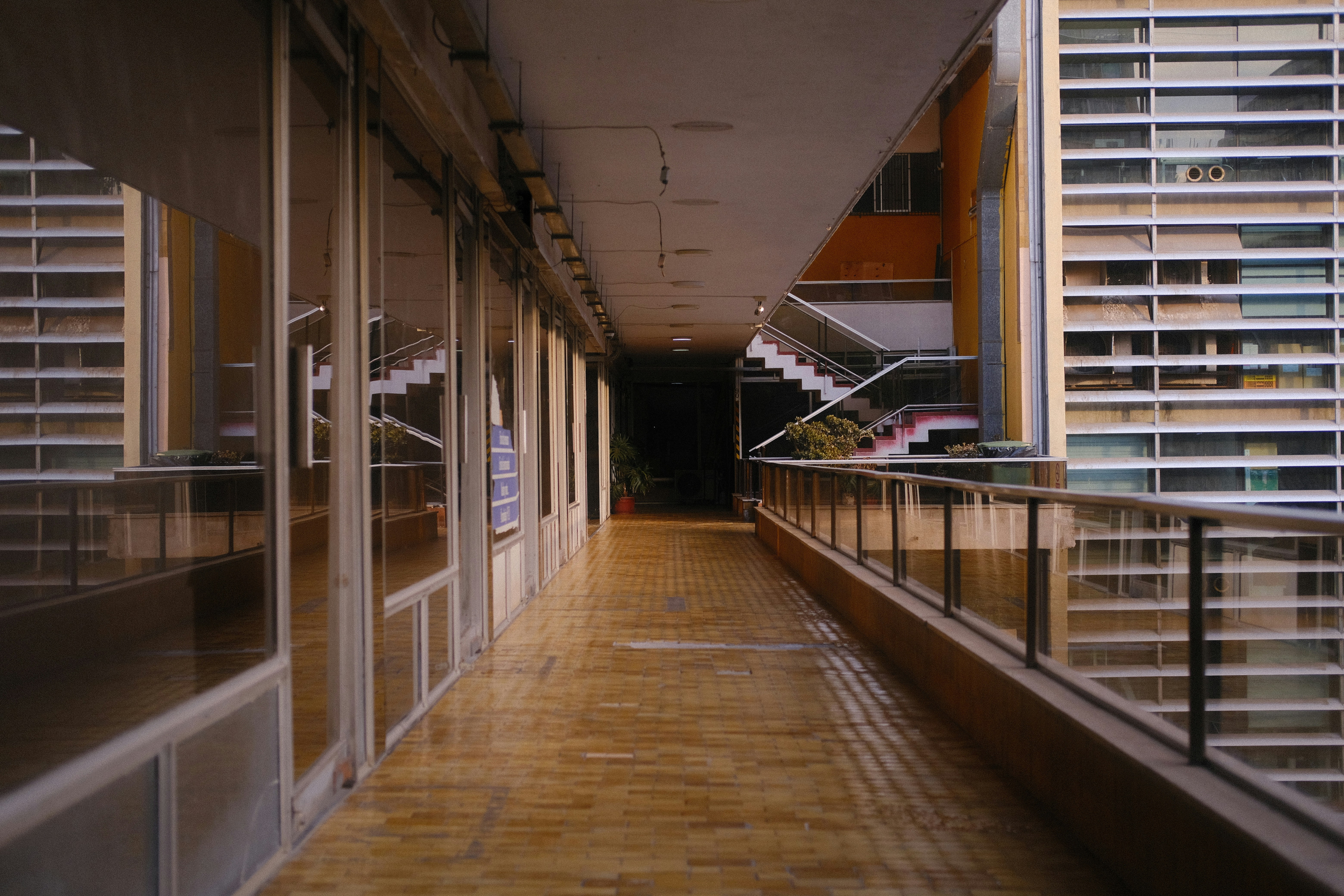 Vanishing Tile: Amber Corridor Between Glass and Steel