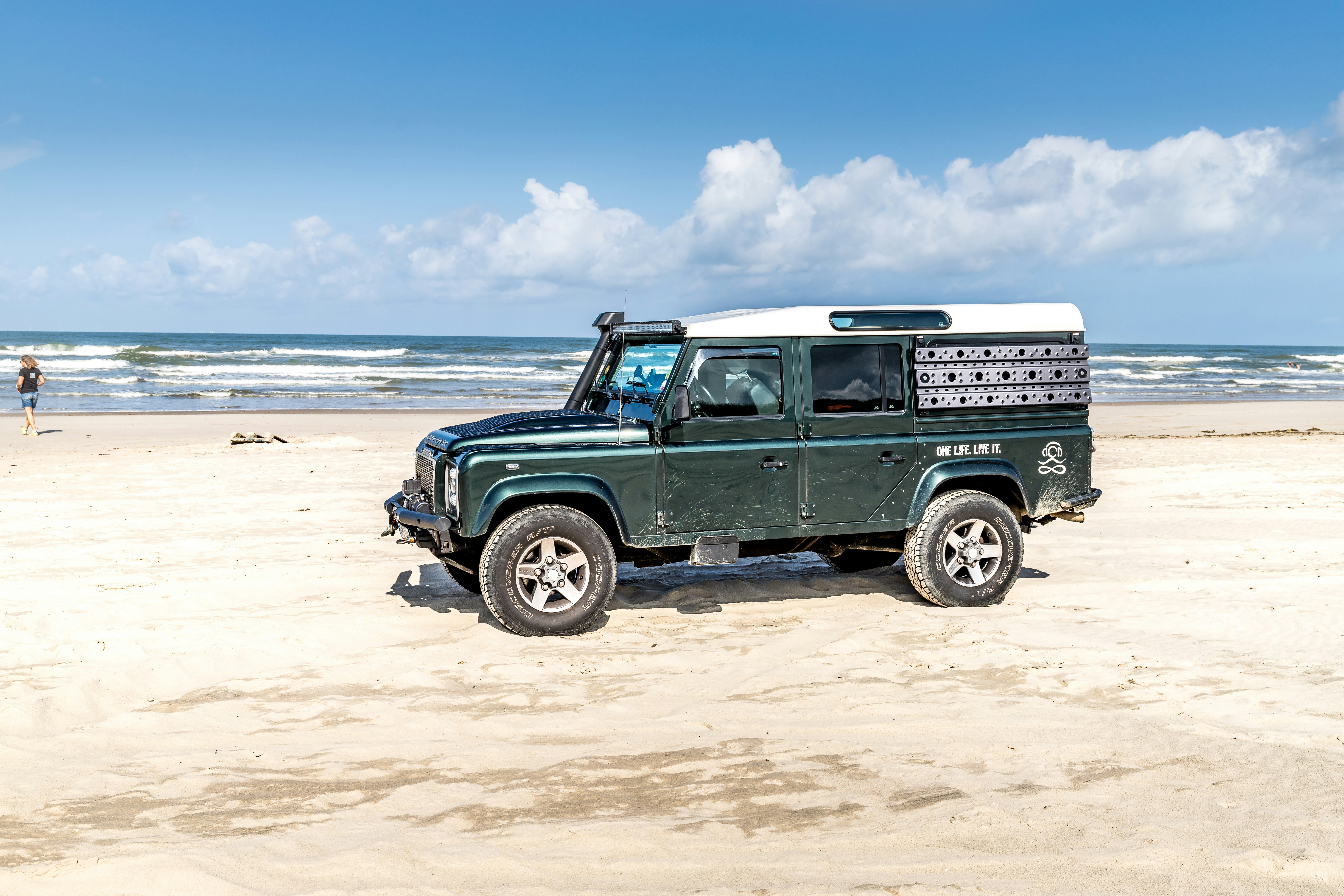 Rugged Beach Workhorse: A Green 4x4 Stationed on Sunrise Shore
