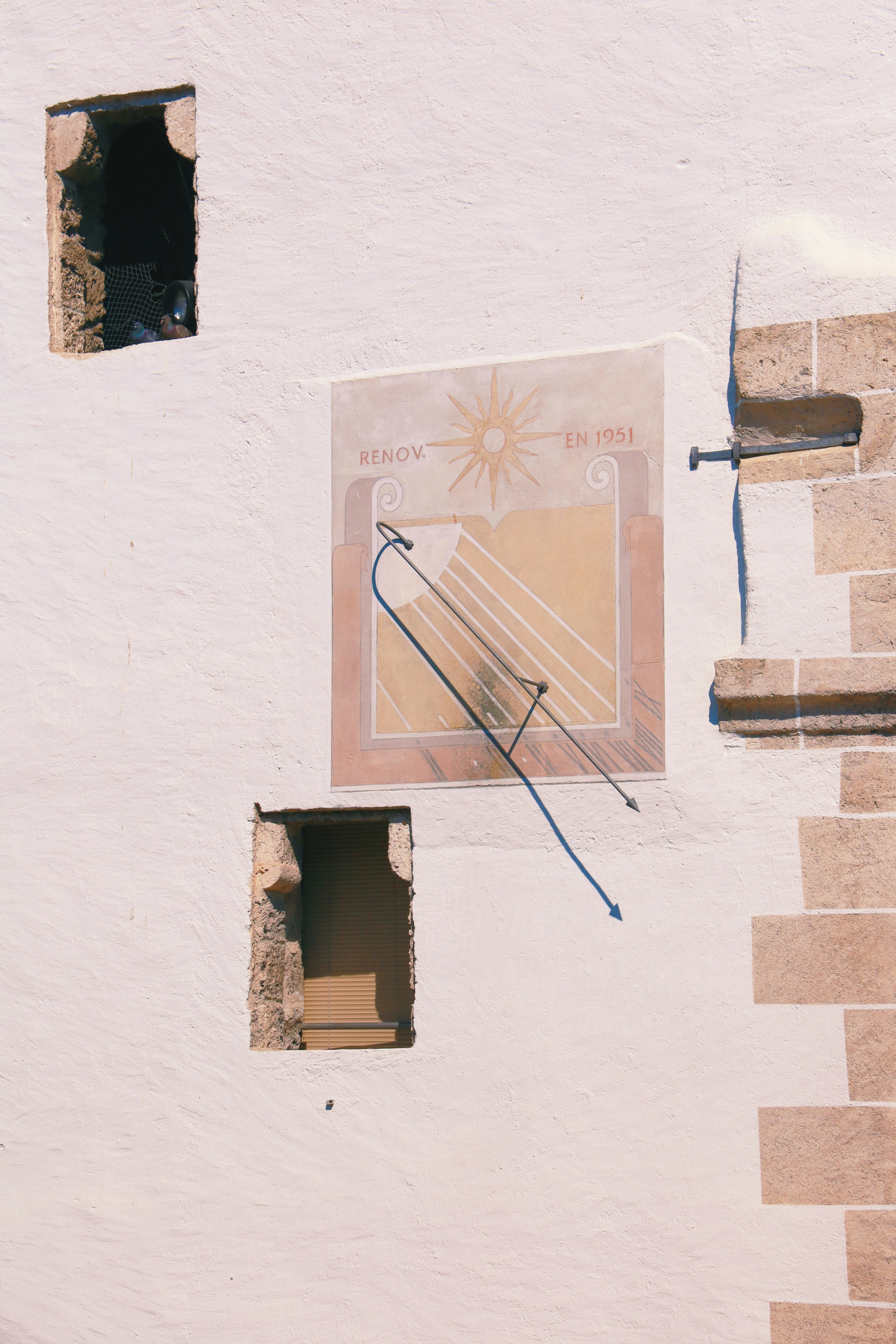 Sunburst Mural on a Pink Facade with Diagonal Wire Motifs