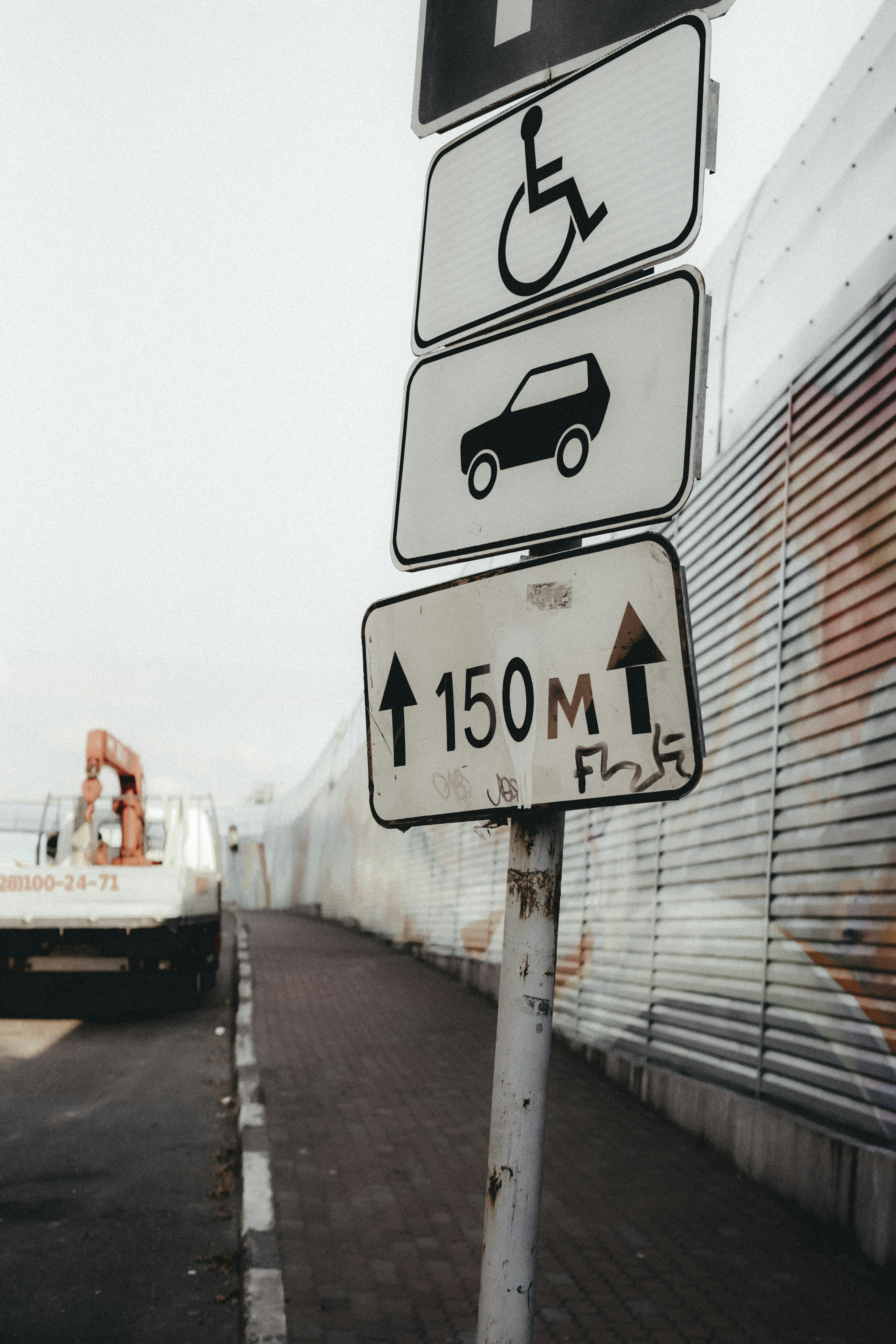 150 Meters Ahead: A Signpost Trio Framing an Industrial Alley