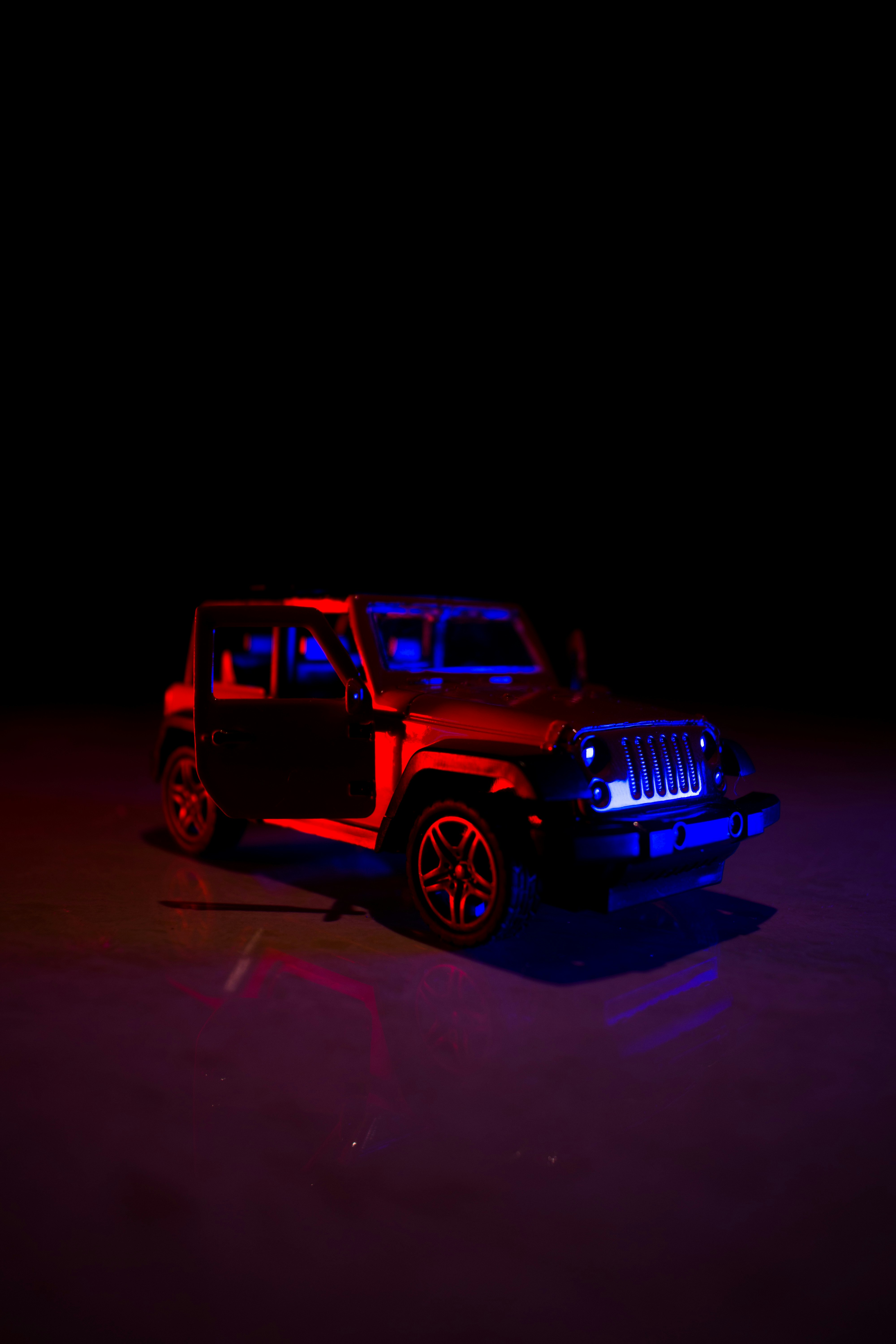 Neon Wrangler: A Miniature Jeep Bathed in Red and Blue Night Light