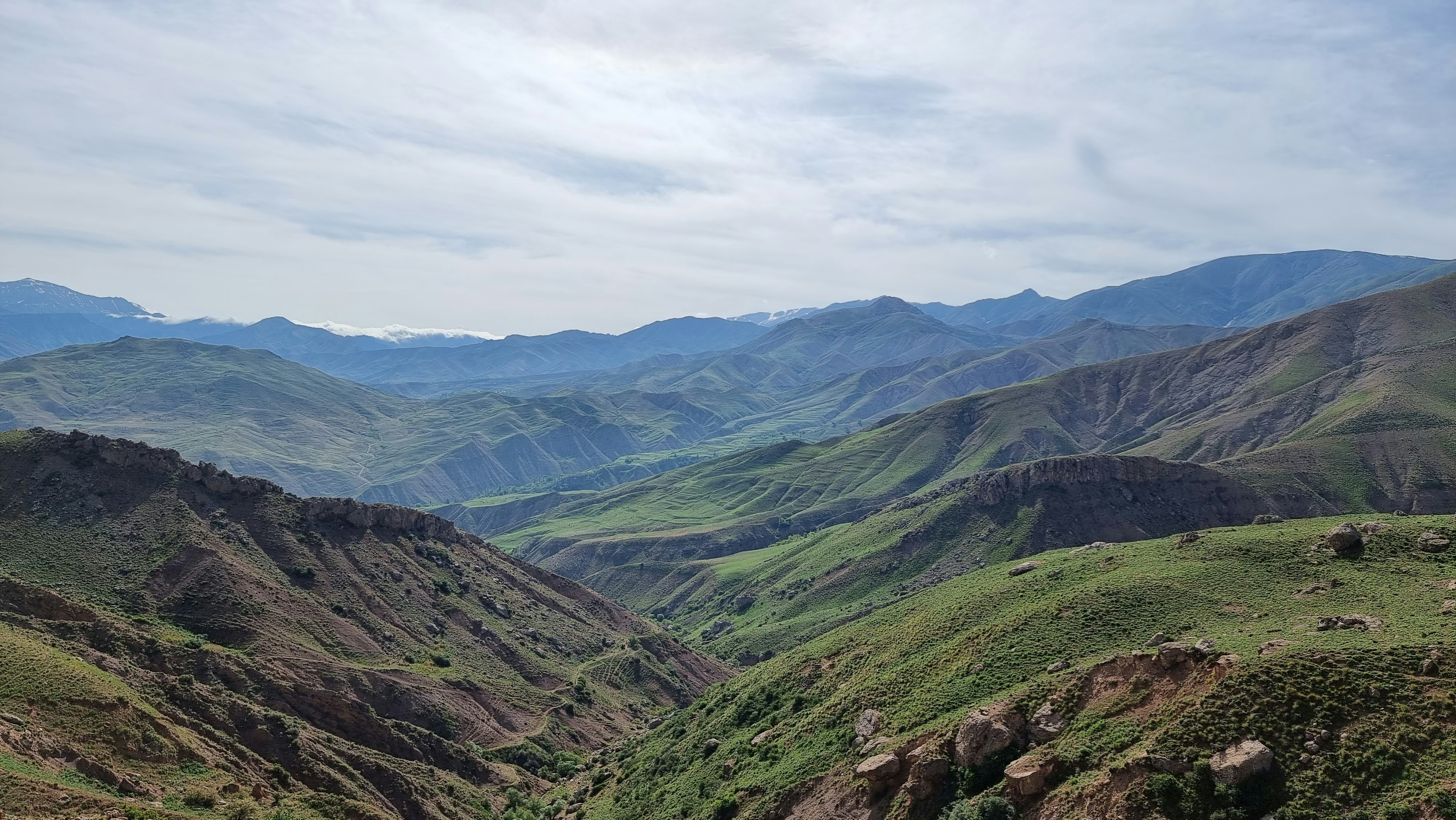 A view of a valley with mountains in the background photo – Free Garden ...