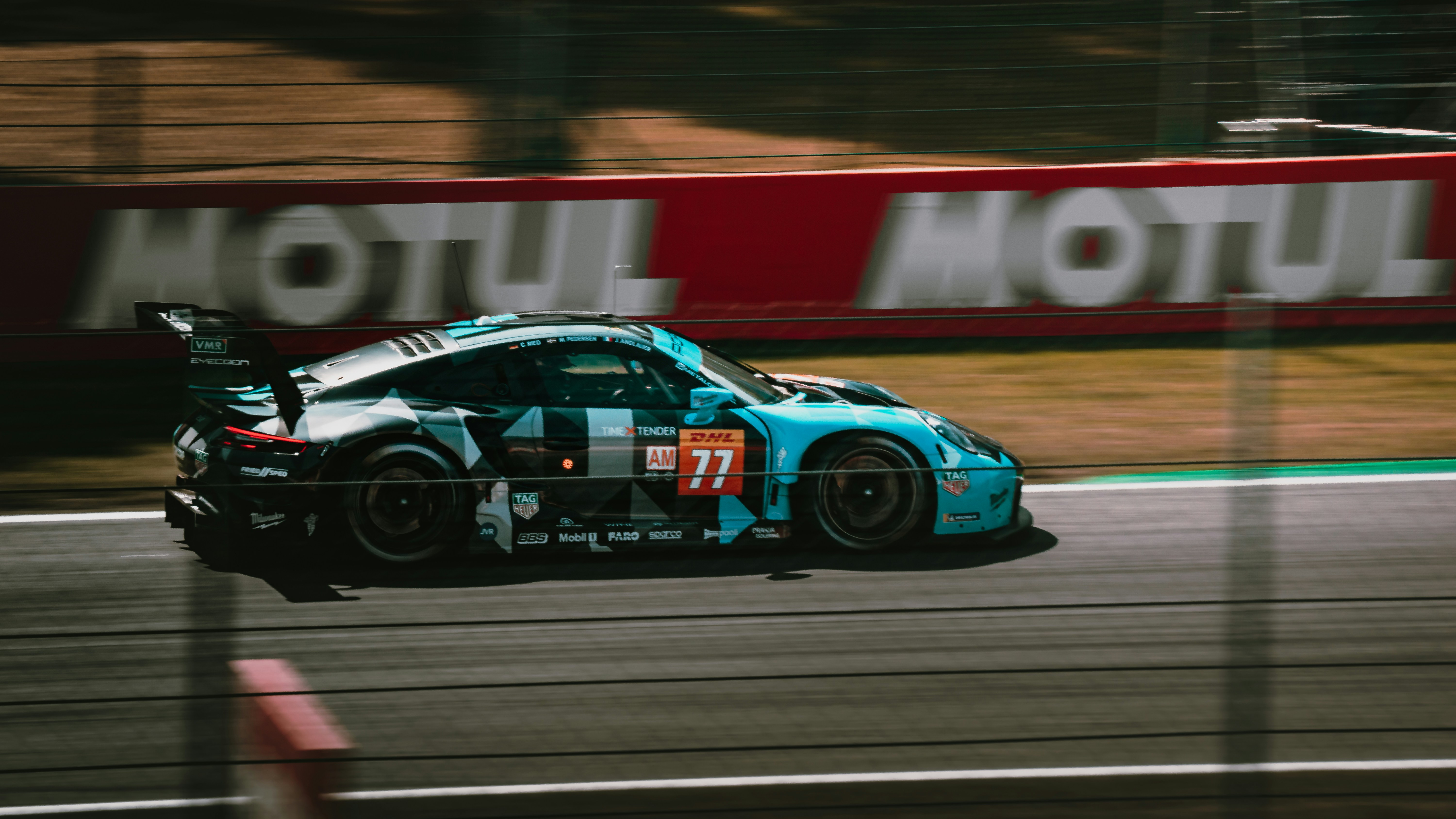 A blue race car driving down a race track photo – Free Autodromo ...