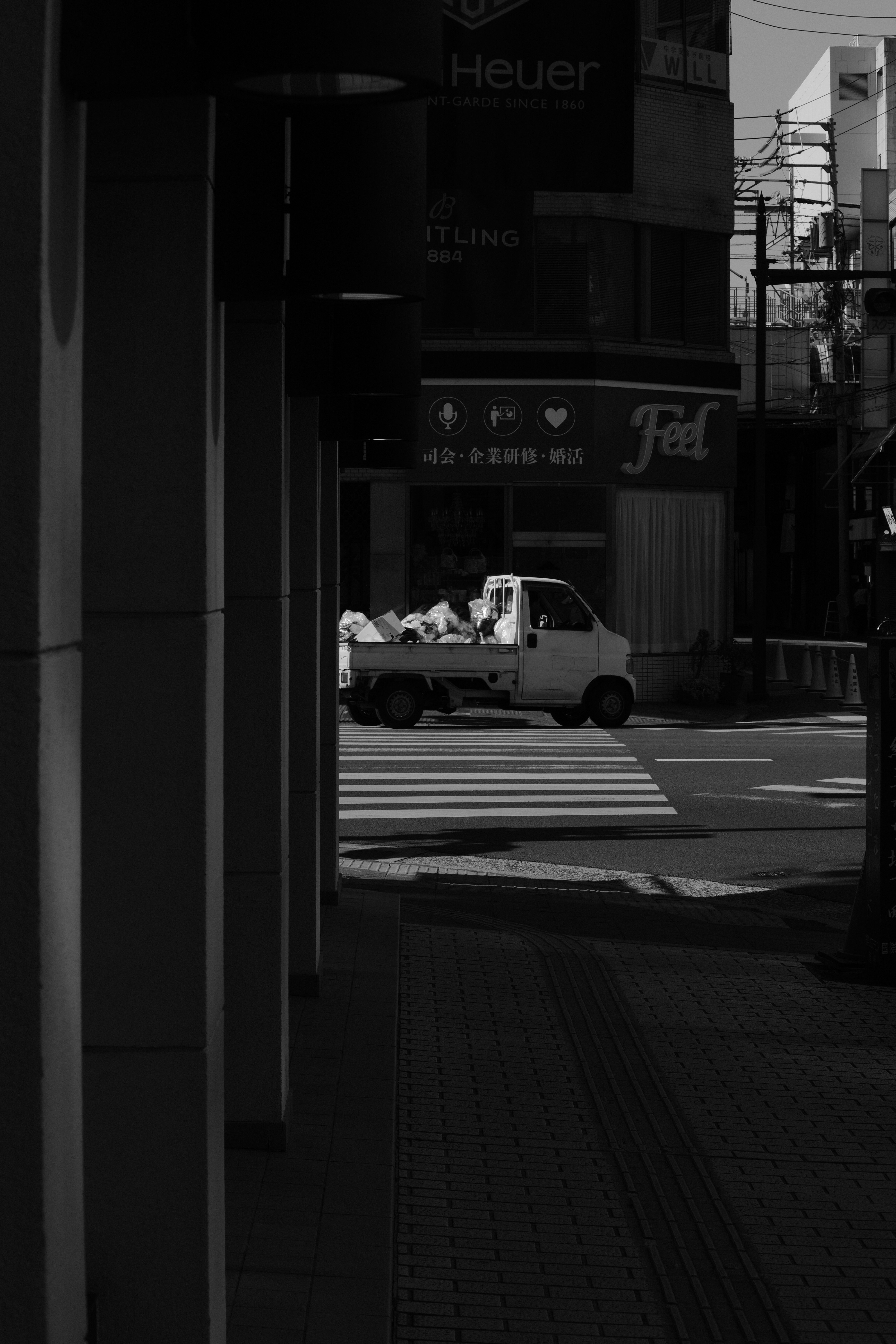 Un camion roulant dans une rue à côté d’un grand immeuble photo – Image ...