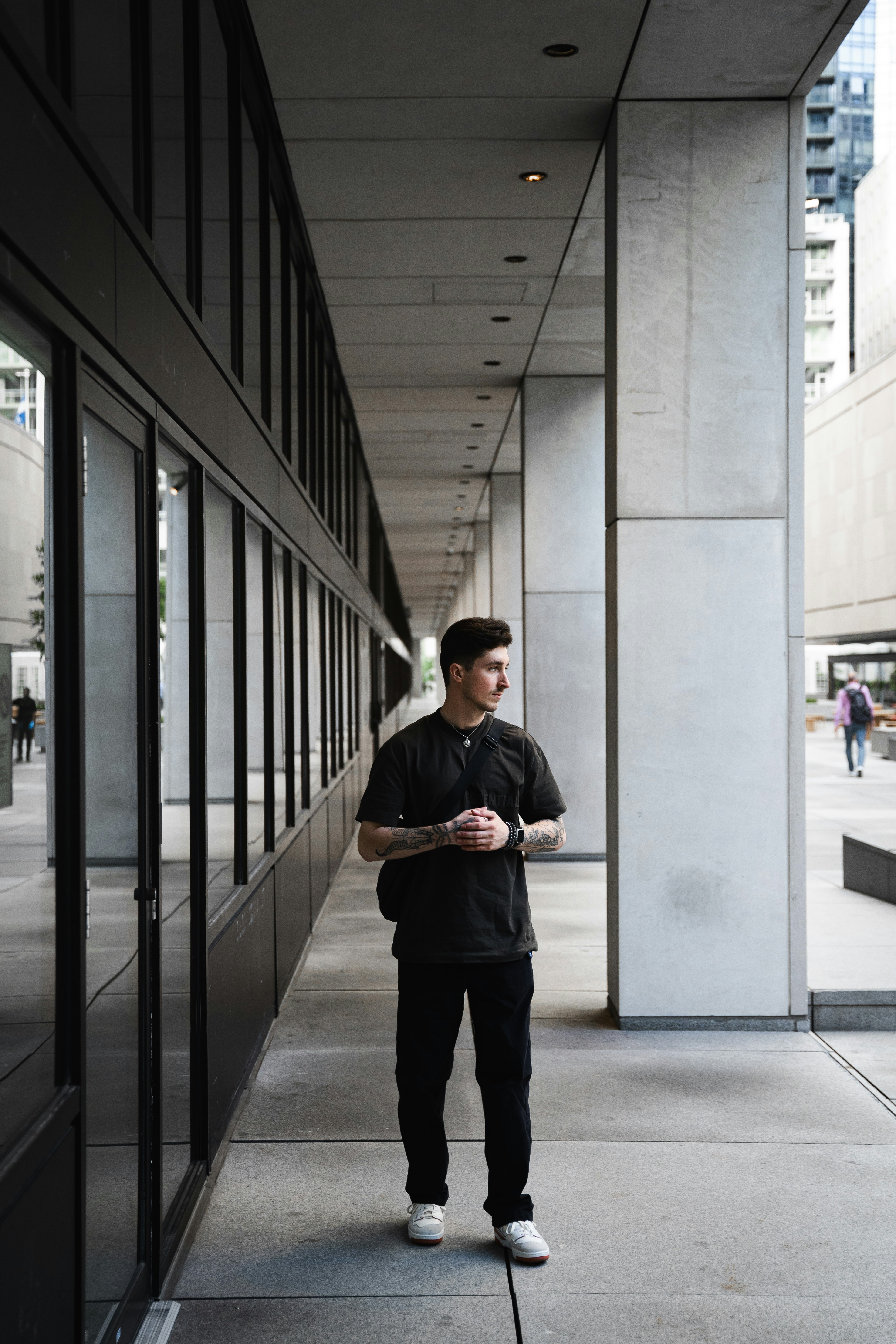 A man standing on a sidewalk next to a building photo – Free Man Image ...