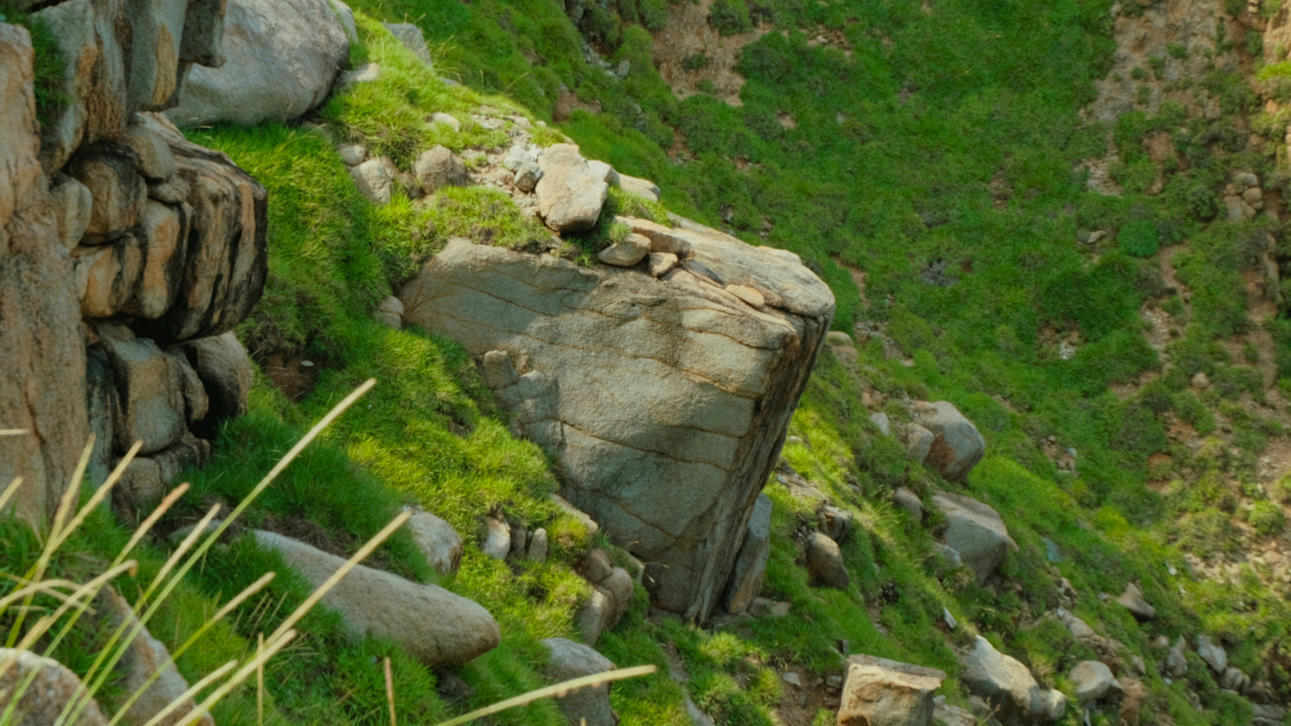 A rocky cliff with grass growing on it photo – Free Vietnam Image on ...