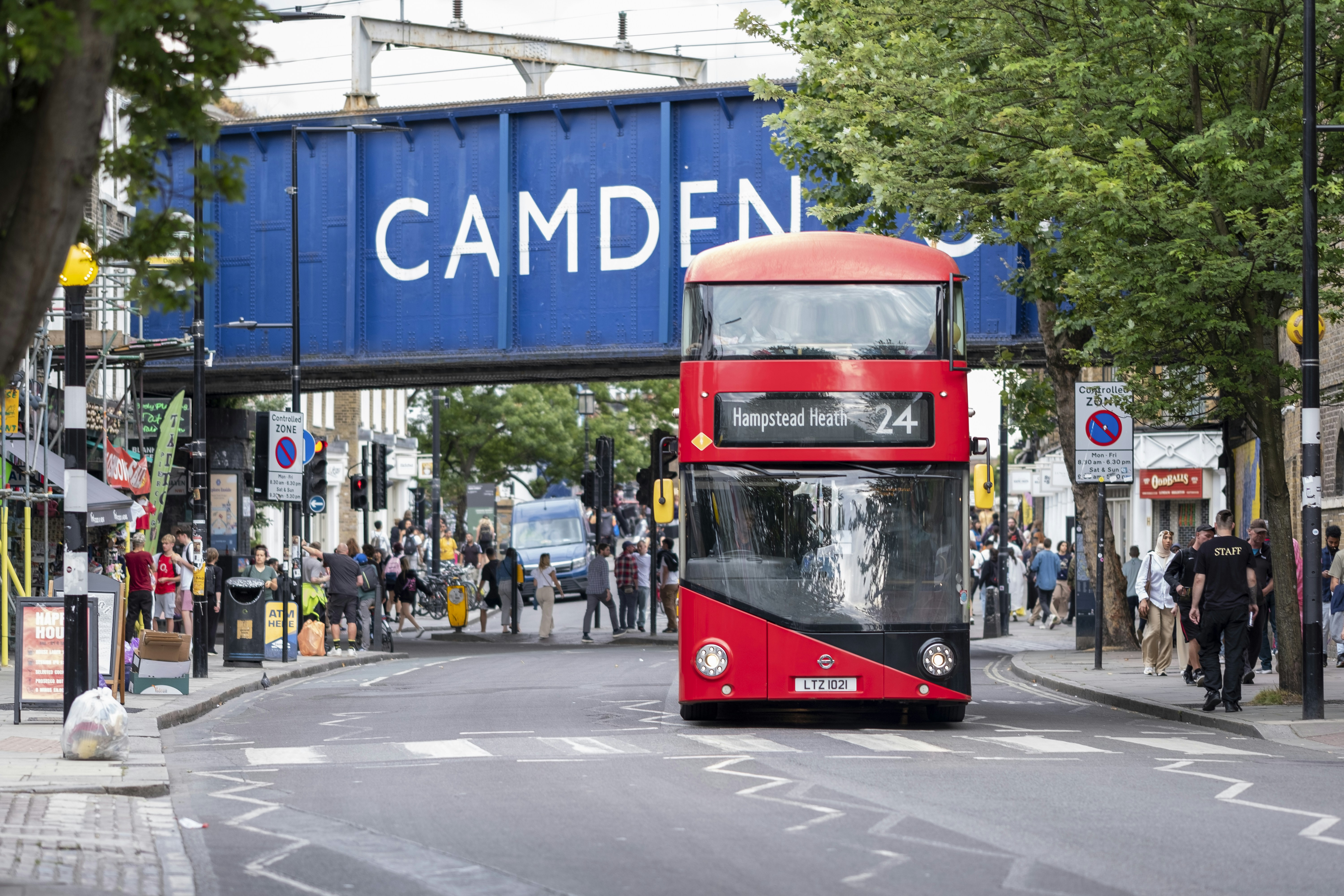 A red double decker bus driving down a street photo – Free Camden town ...