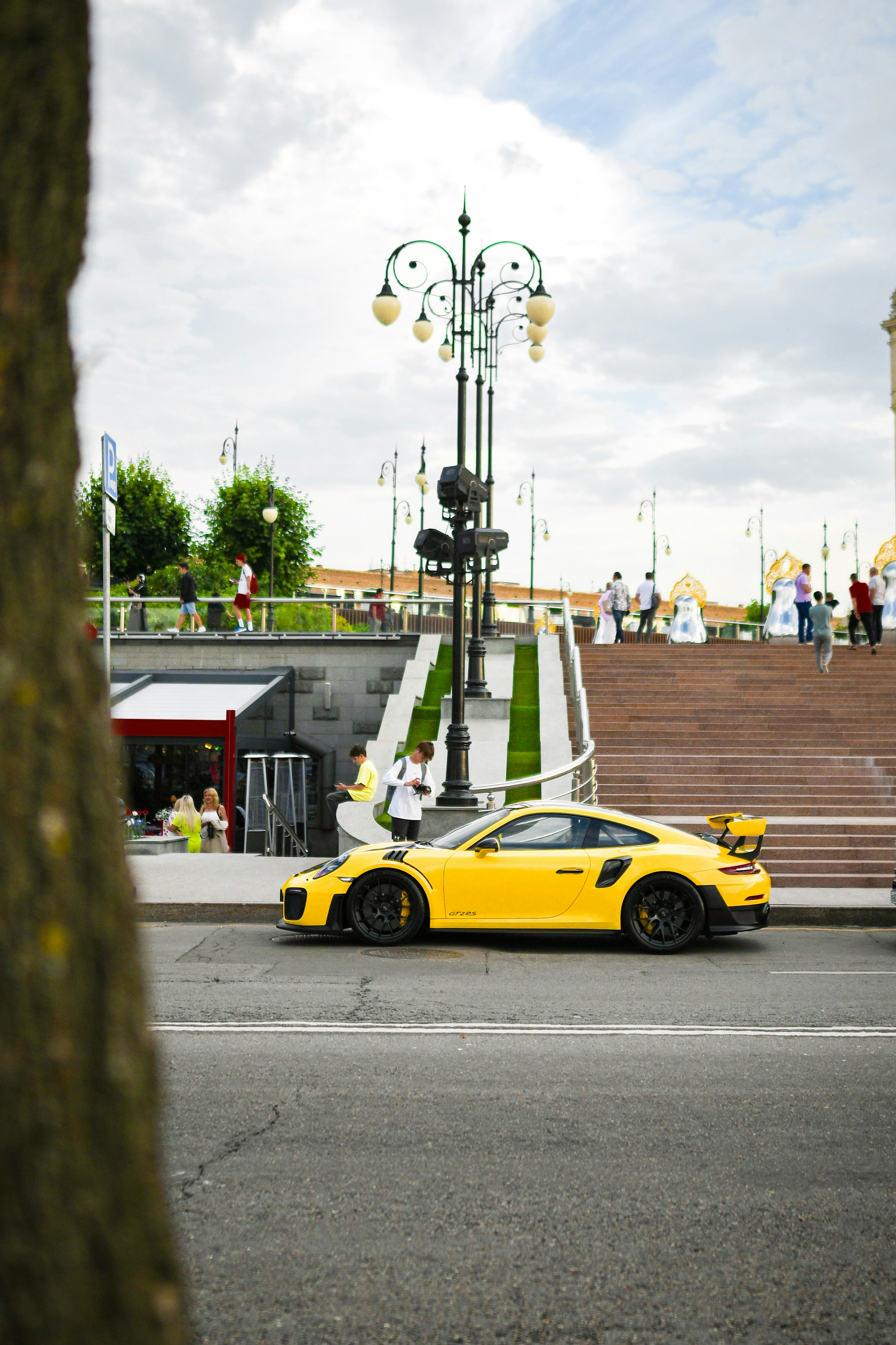 Sunlit Yellow Porsche Resting by the Riverside Staircase