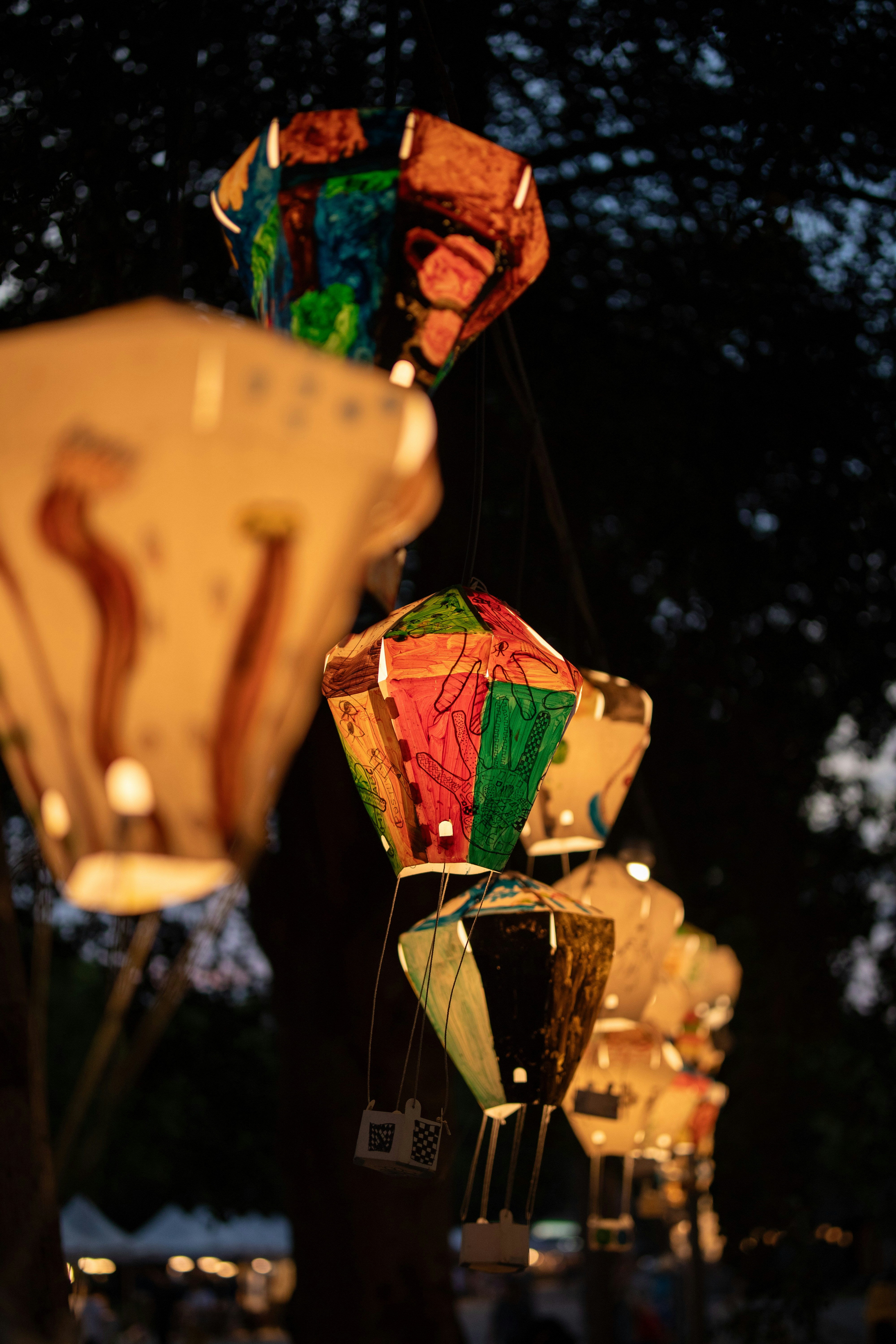 A group of colorful kites hanging from a tree photo – Free Lighting ...