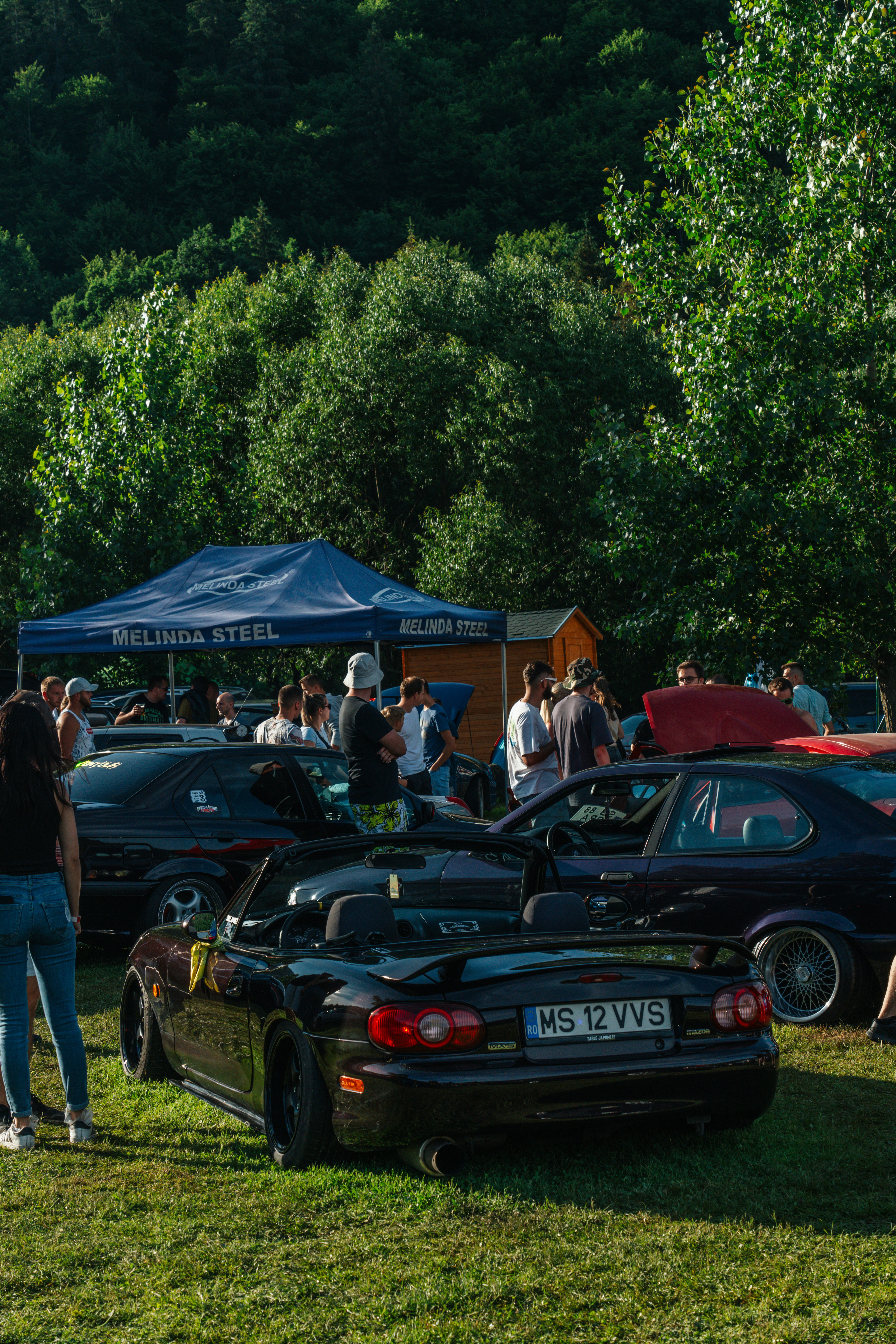 Shadows and Shine at the Meadow Car Meet: A Black Convertible Anchors the Scene