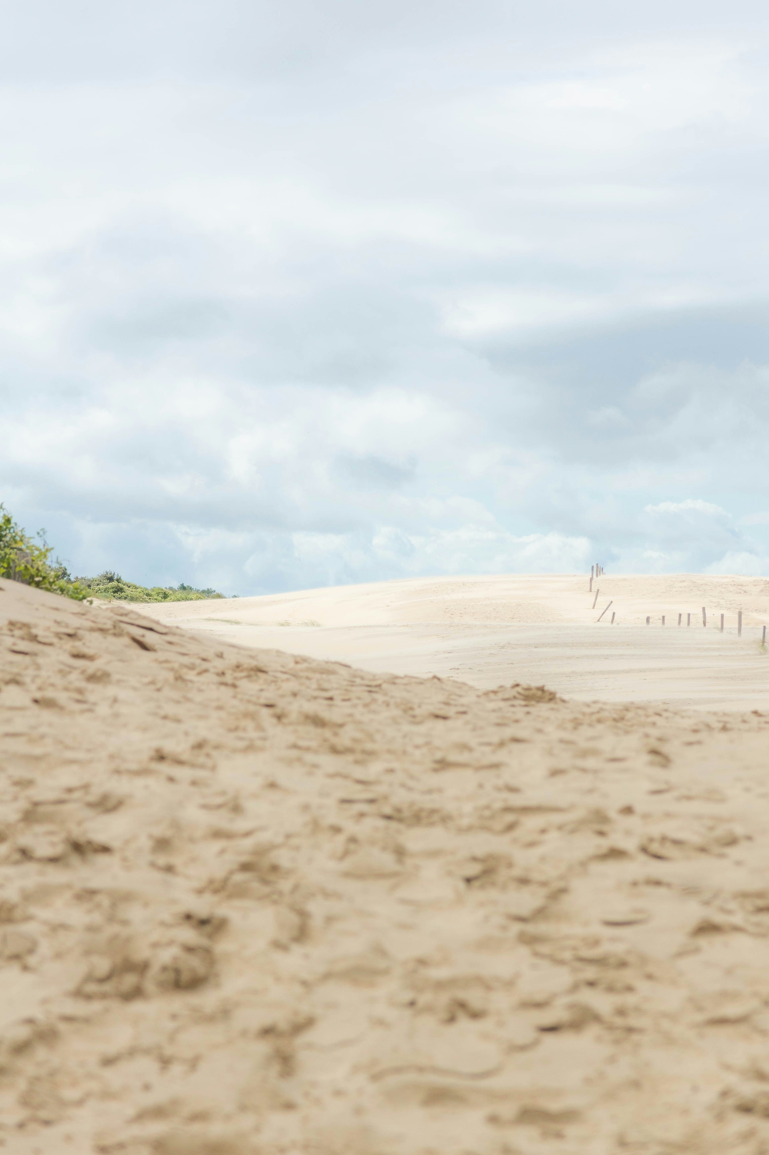 a person walking on a beach carrying a surfboard