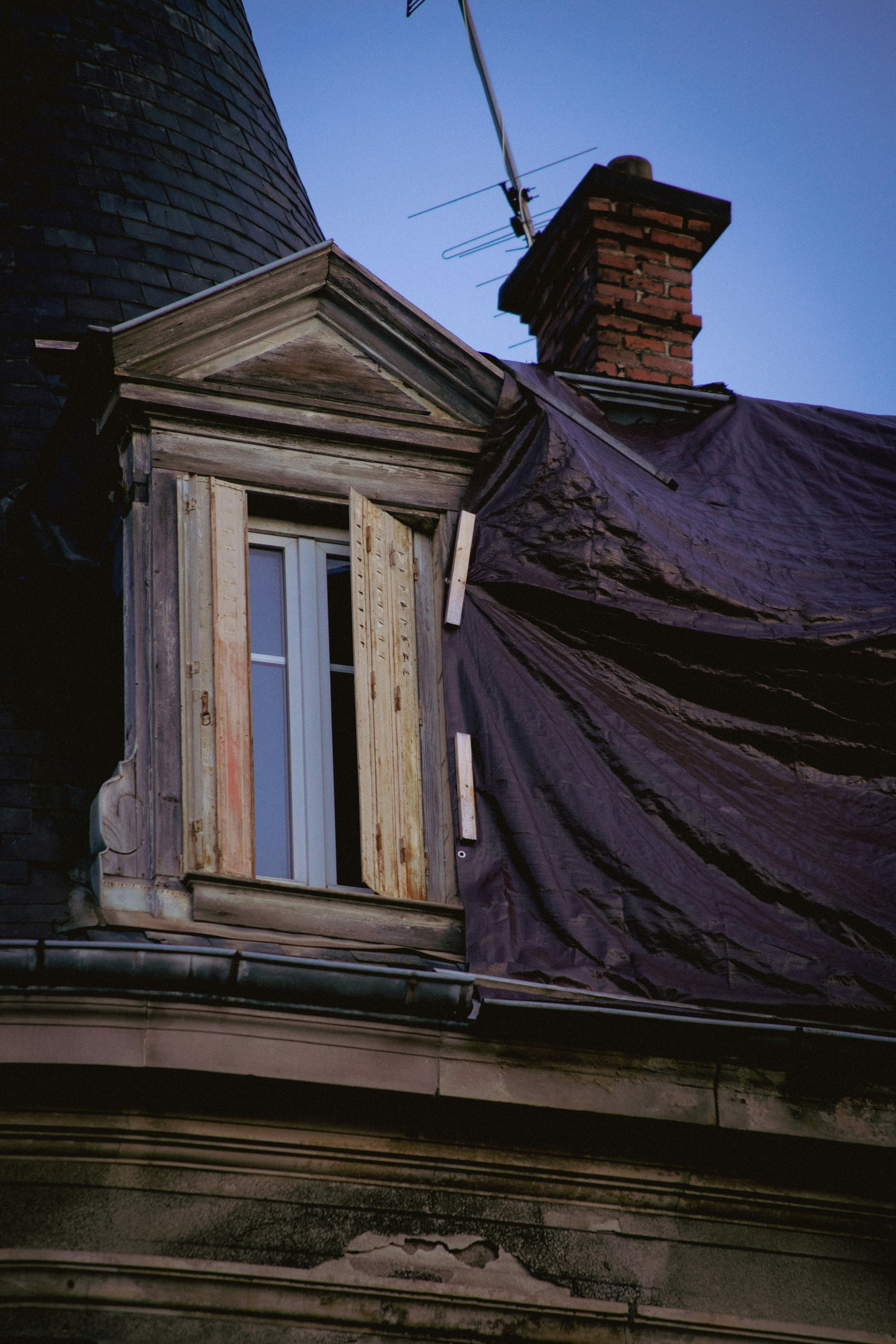 Shuttered Dormer Portrait: Weathered Wood Beneath a Slate Rooftop