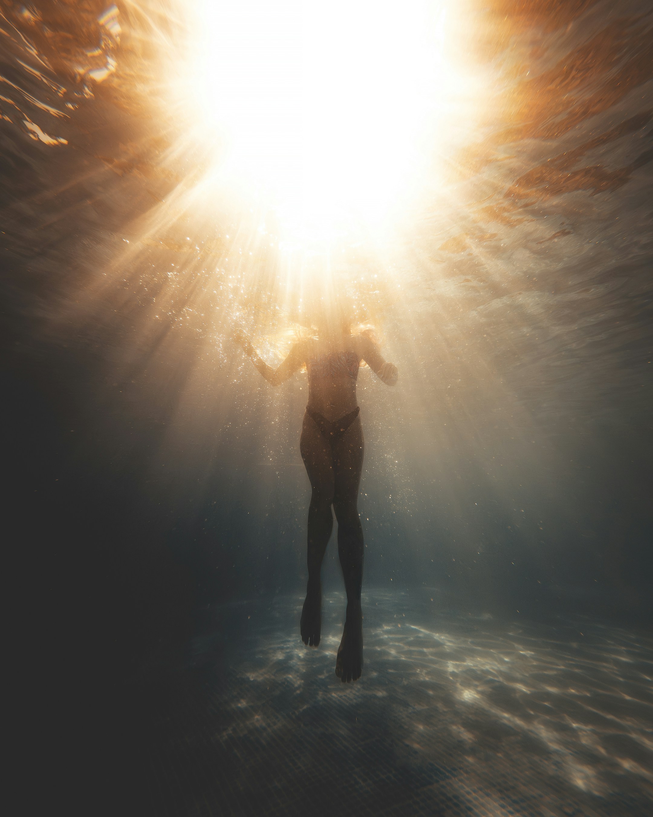 A person standing under the sun in the water photo – Free Swimming pool ...