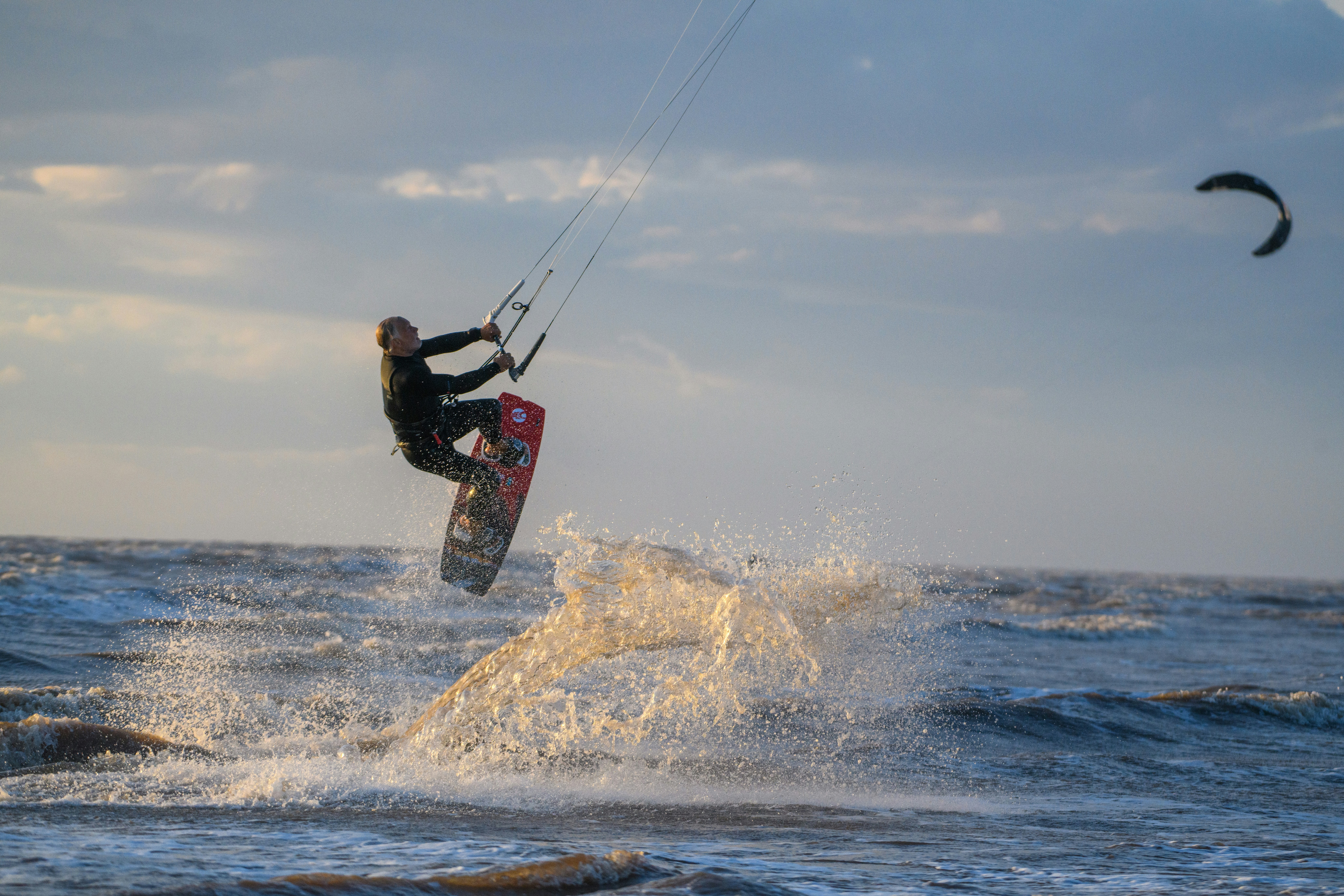 A man riding a kiteboard on top of a wave in the ocean photo – Free ...