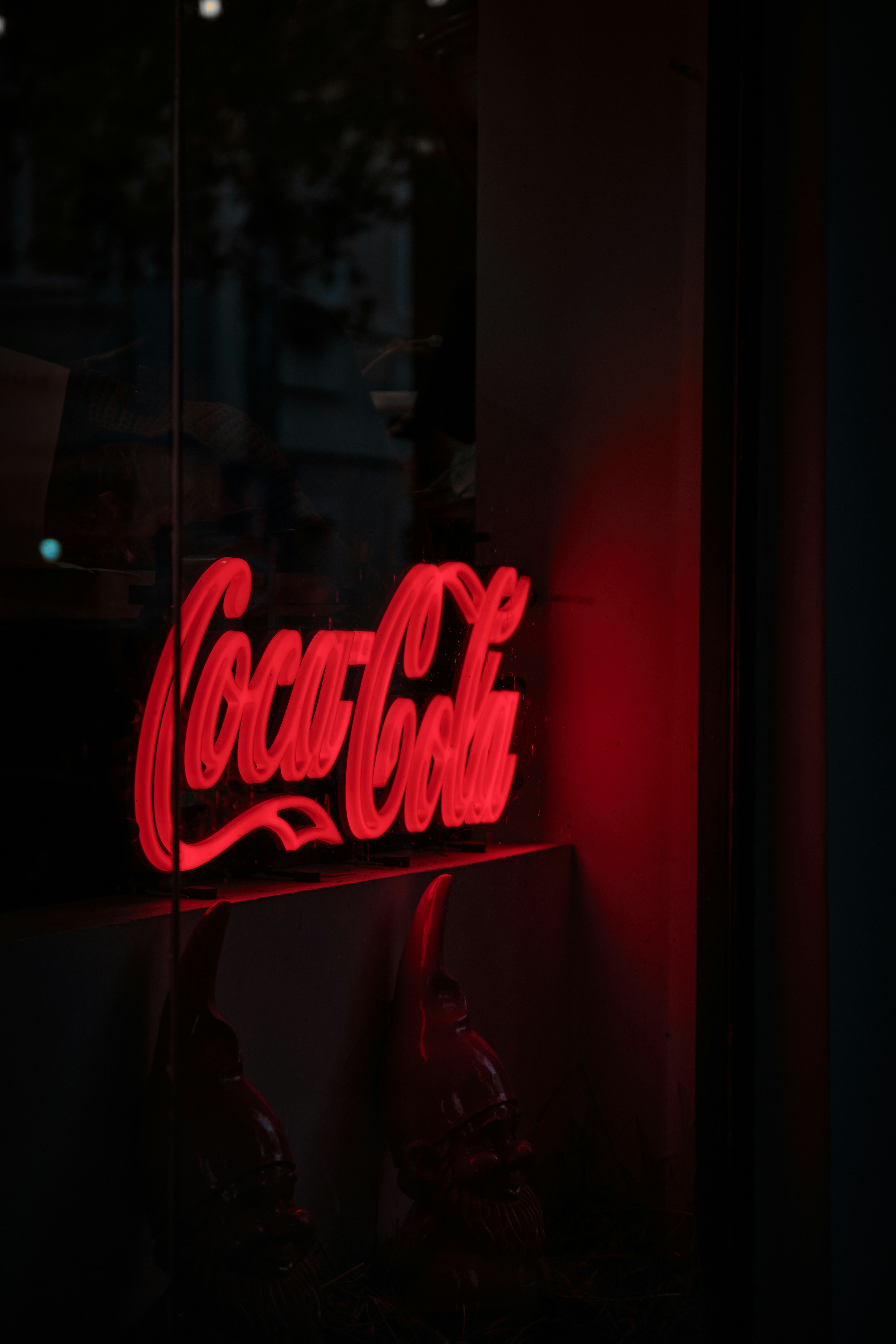 Crimson Neon Through a Dark Window: Coca-Cola Sign Reflections