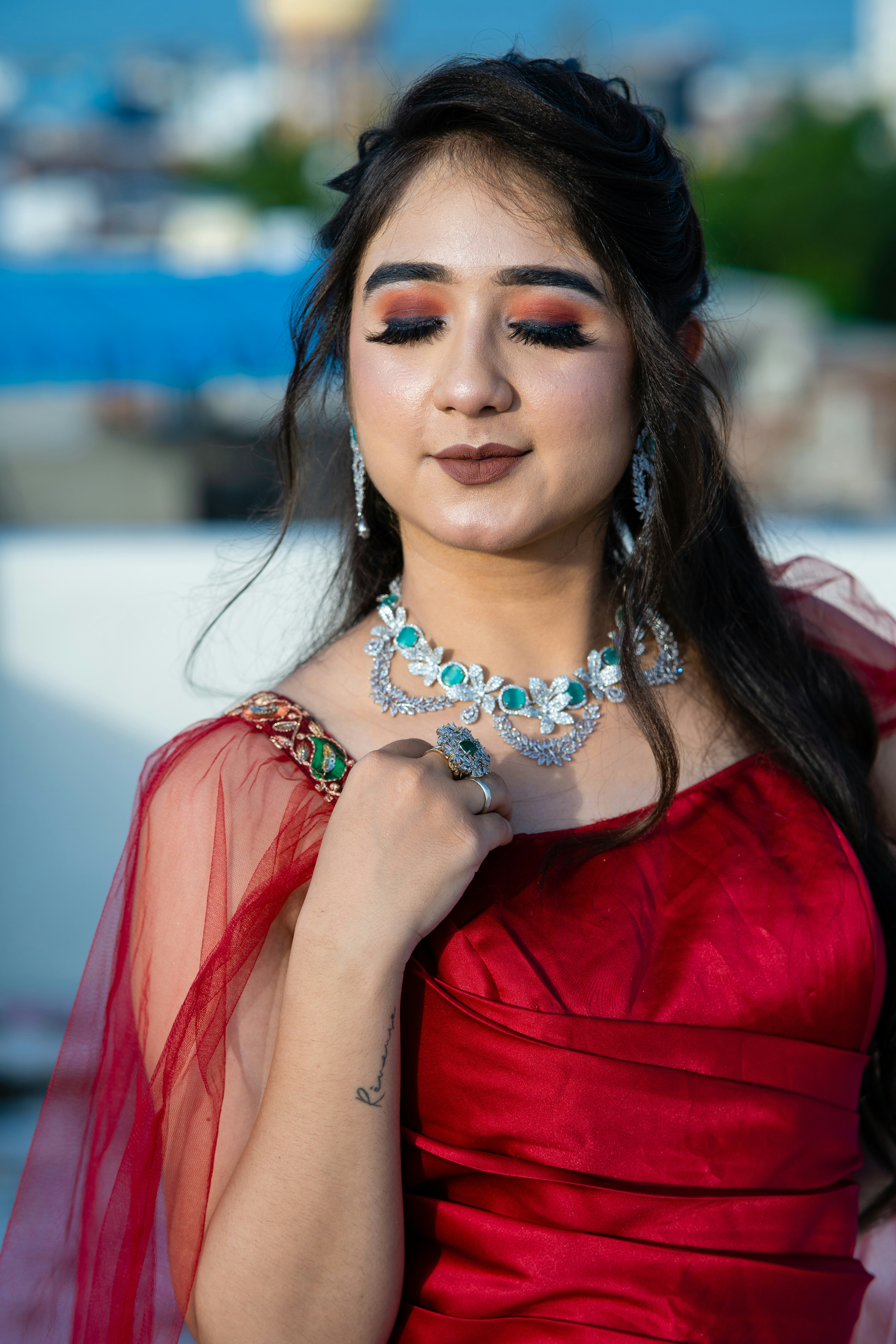 A woman in a red dress wearing a necklace and earrings photo – Free ...
