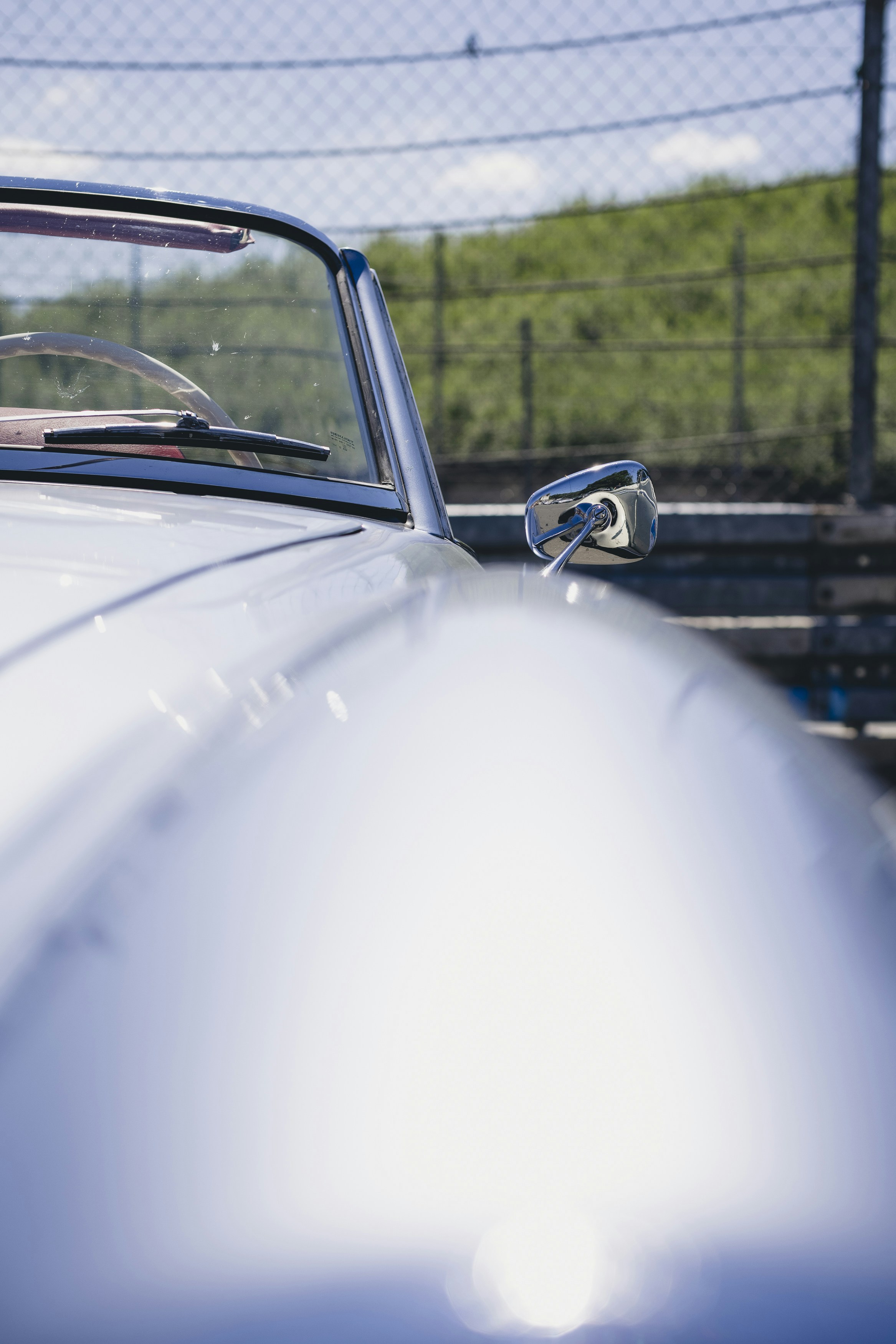 Chrome Mirror and Curvature: A Low-Angle Glimpse of a Classic Convertible