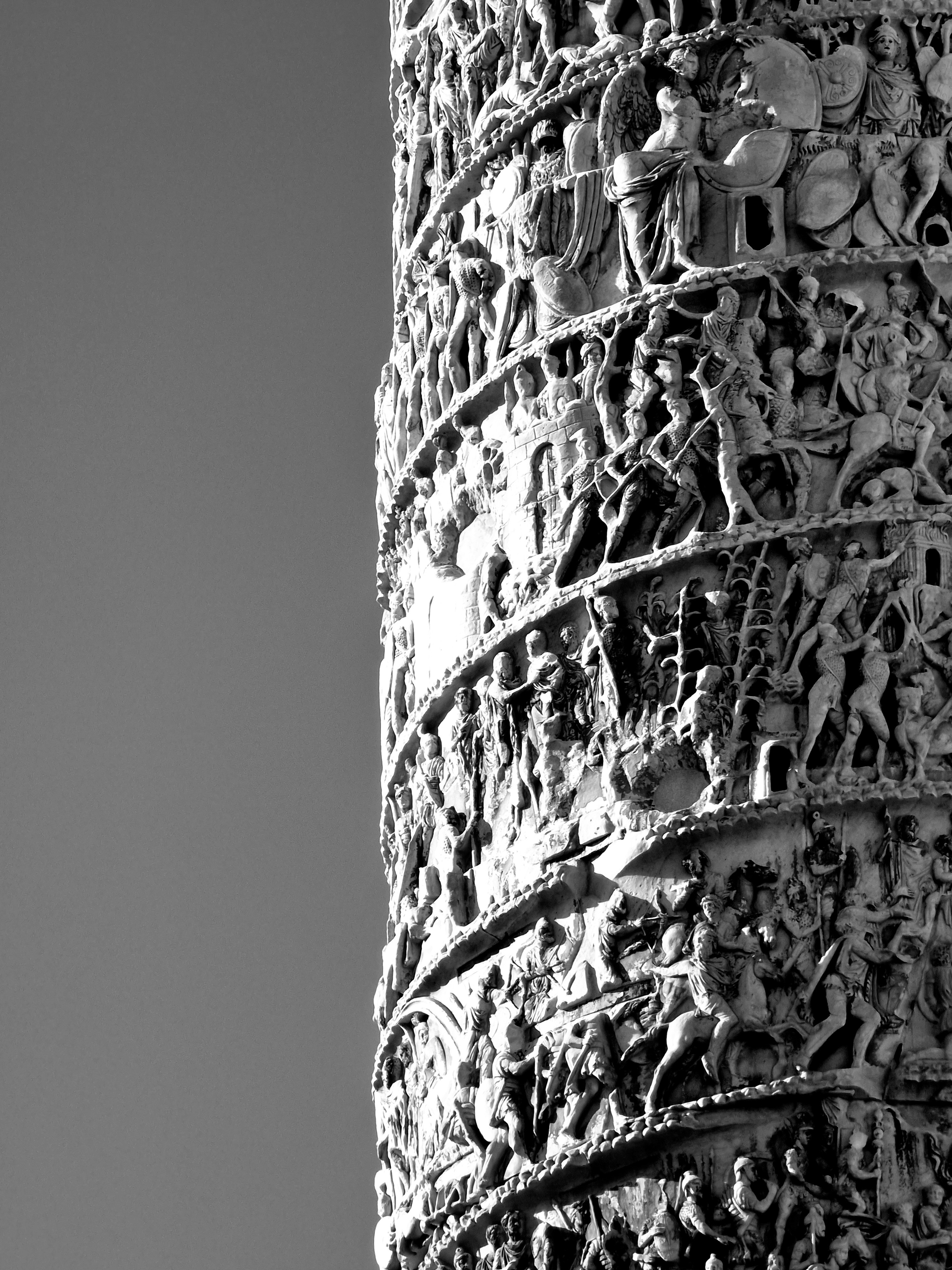 Sculpted Time: A Column of Ancient Figures in Monochrome