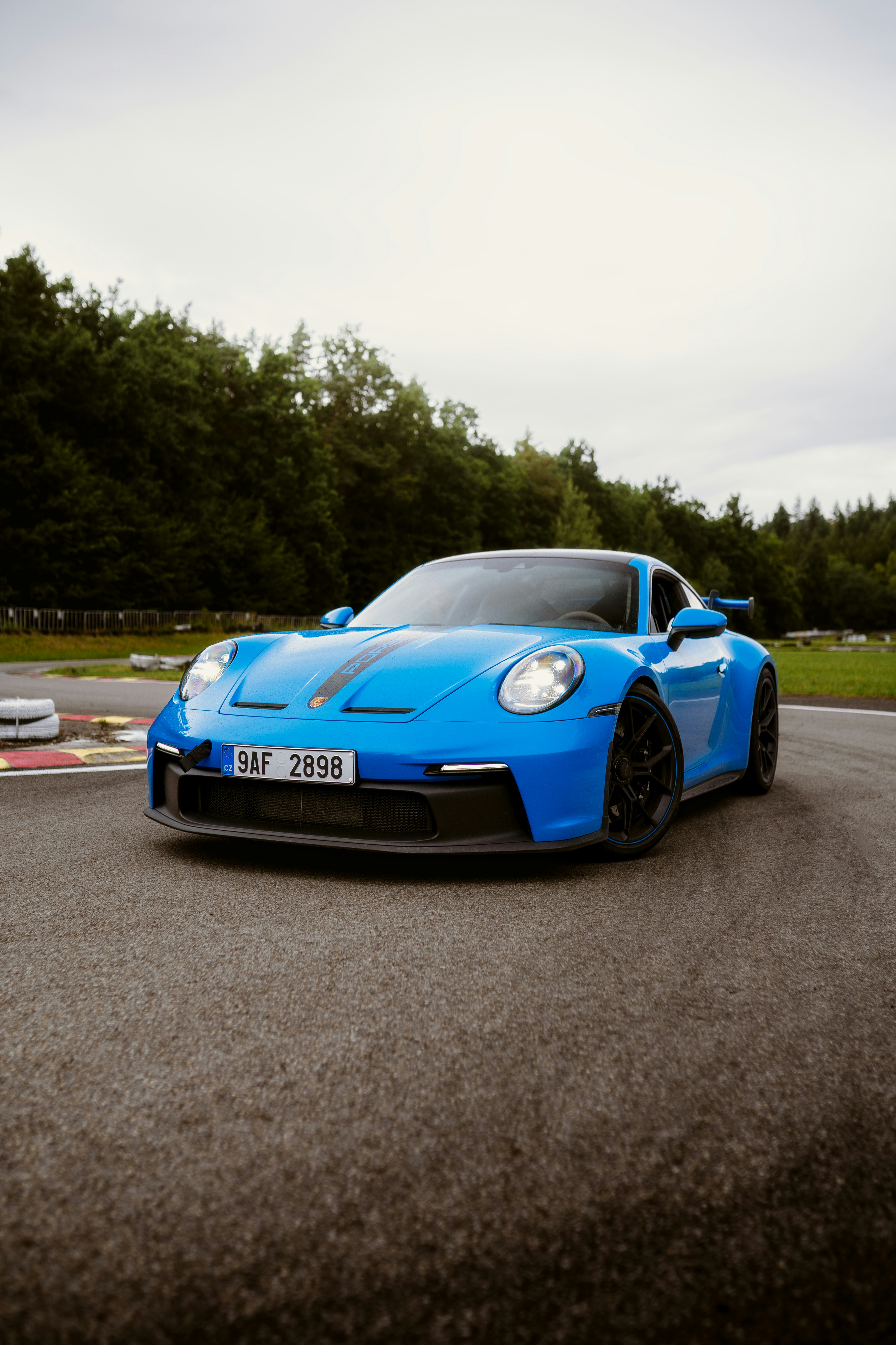 A blue sports car driving down a race track photo – Free Czechia Image ...