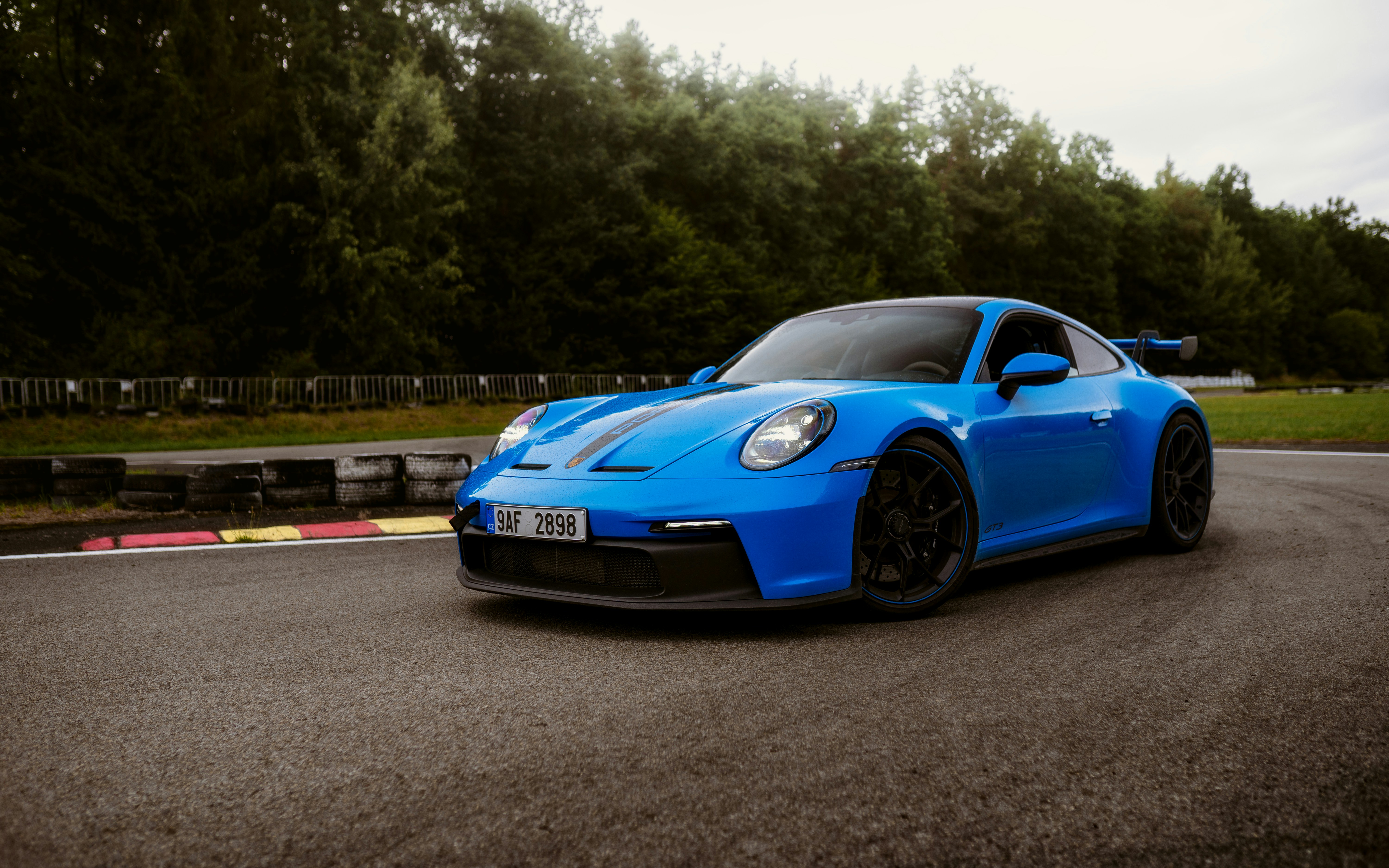 A blue sports car driving down a race track photo – Free Czechia Image ...