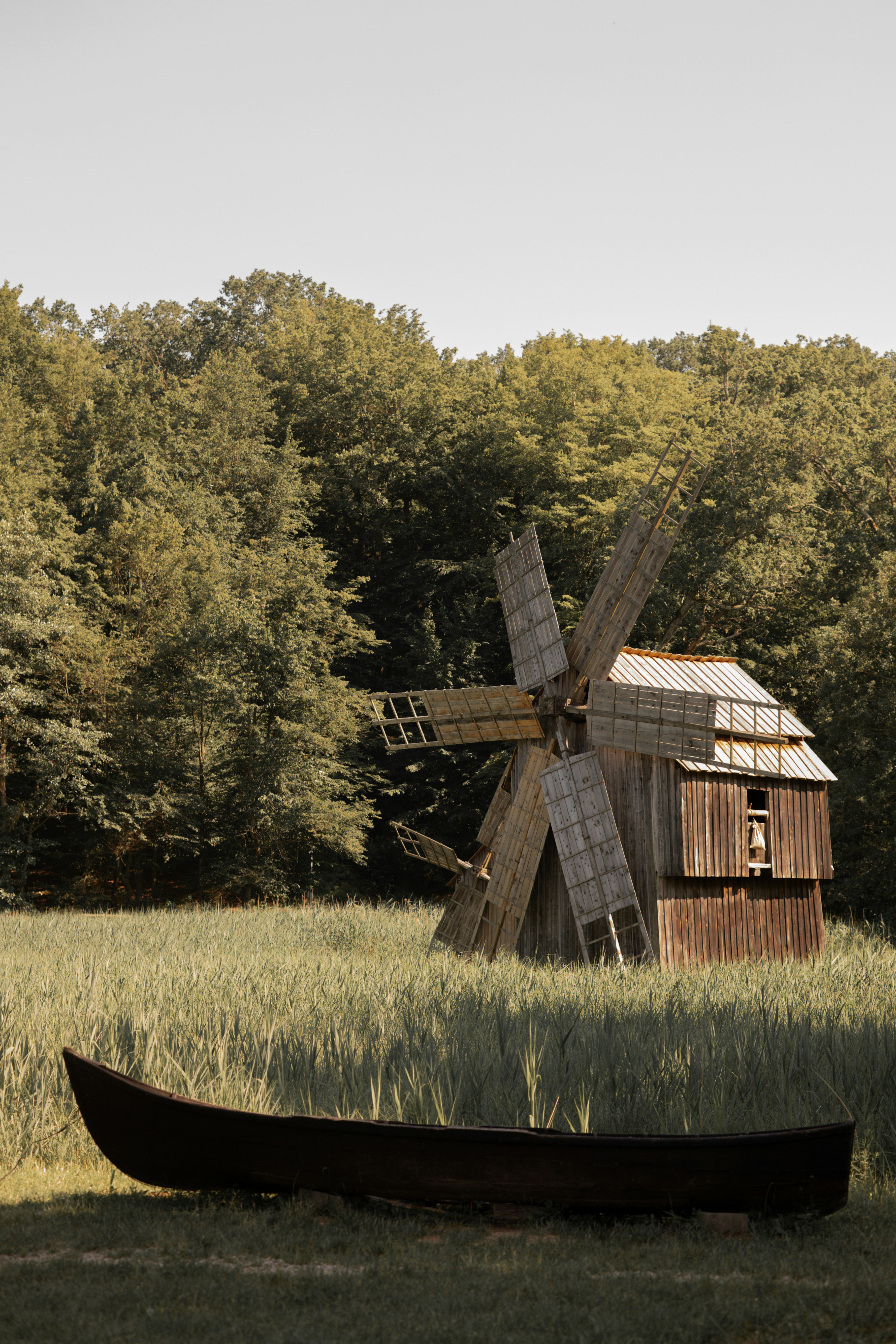 A boat sitting in a field next to a windmill photo – Free Romania Image ...