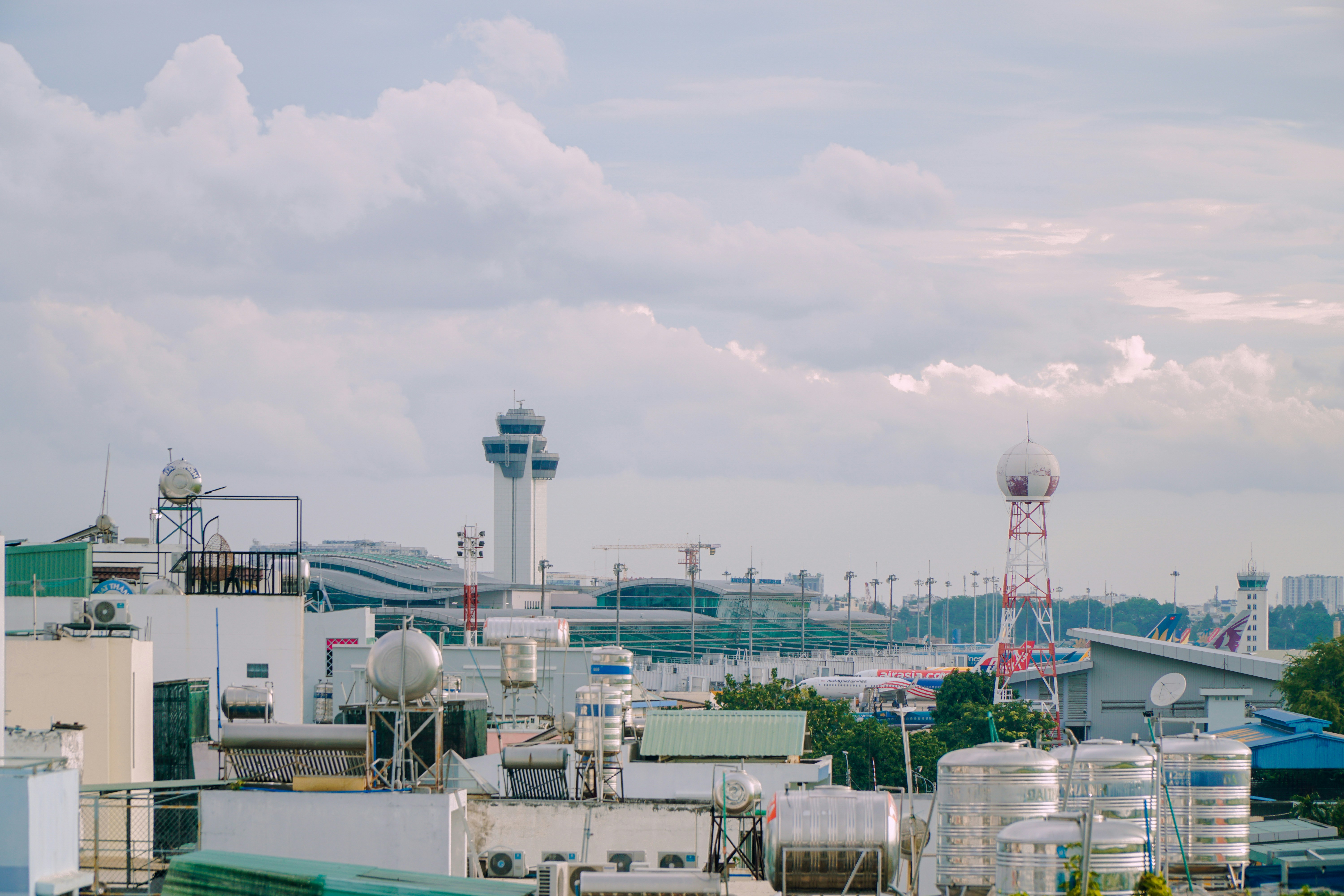 Rooftop Echoes: A Cityscape Framed by a Distant Control Tower