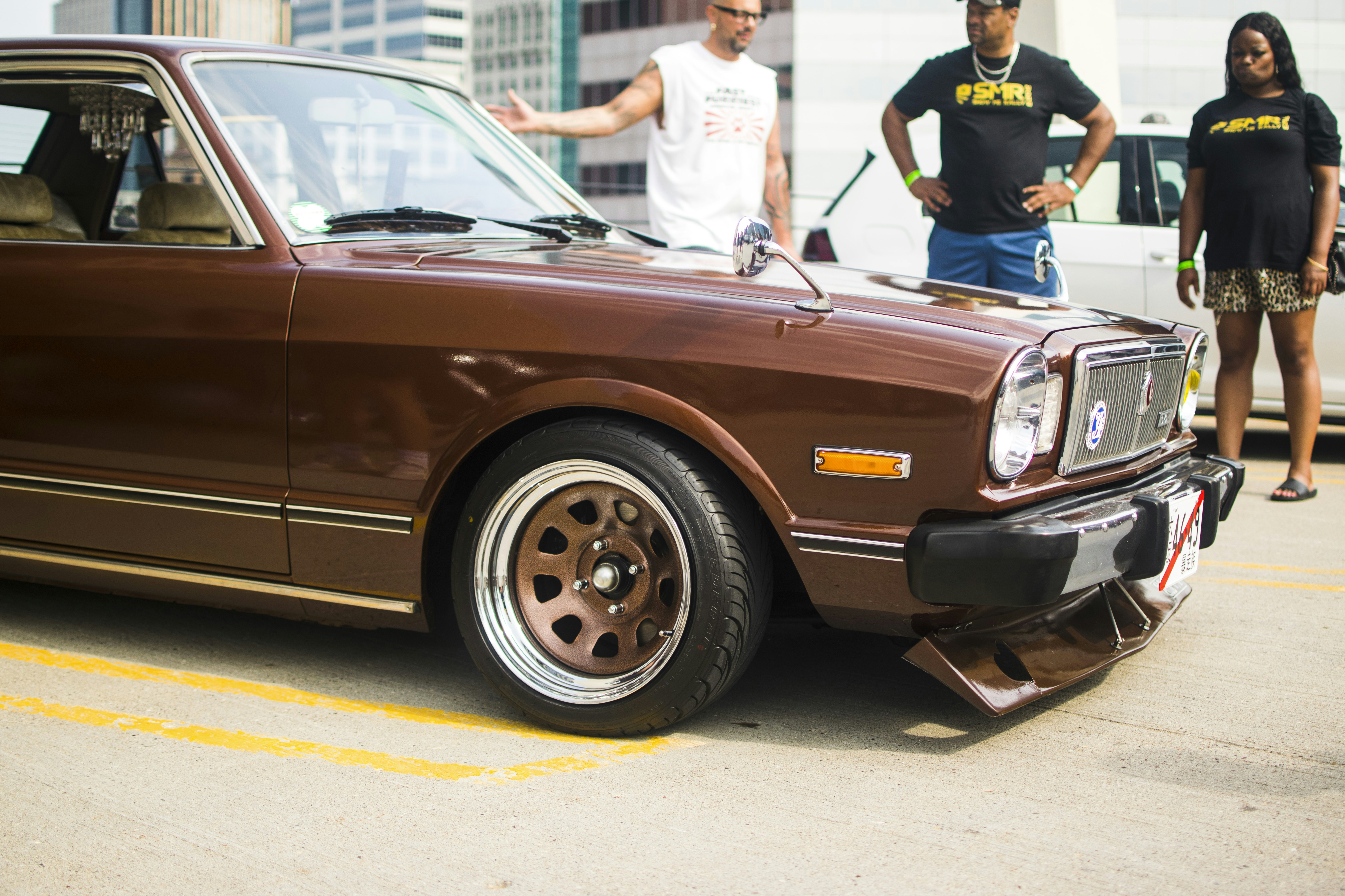 Mid-century Bronze Sedan Framed by a Curious Crowd