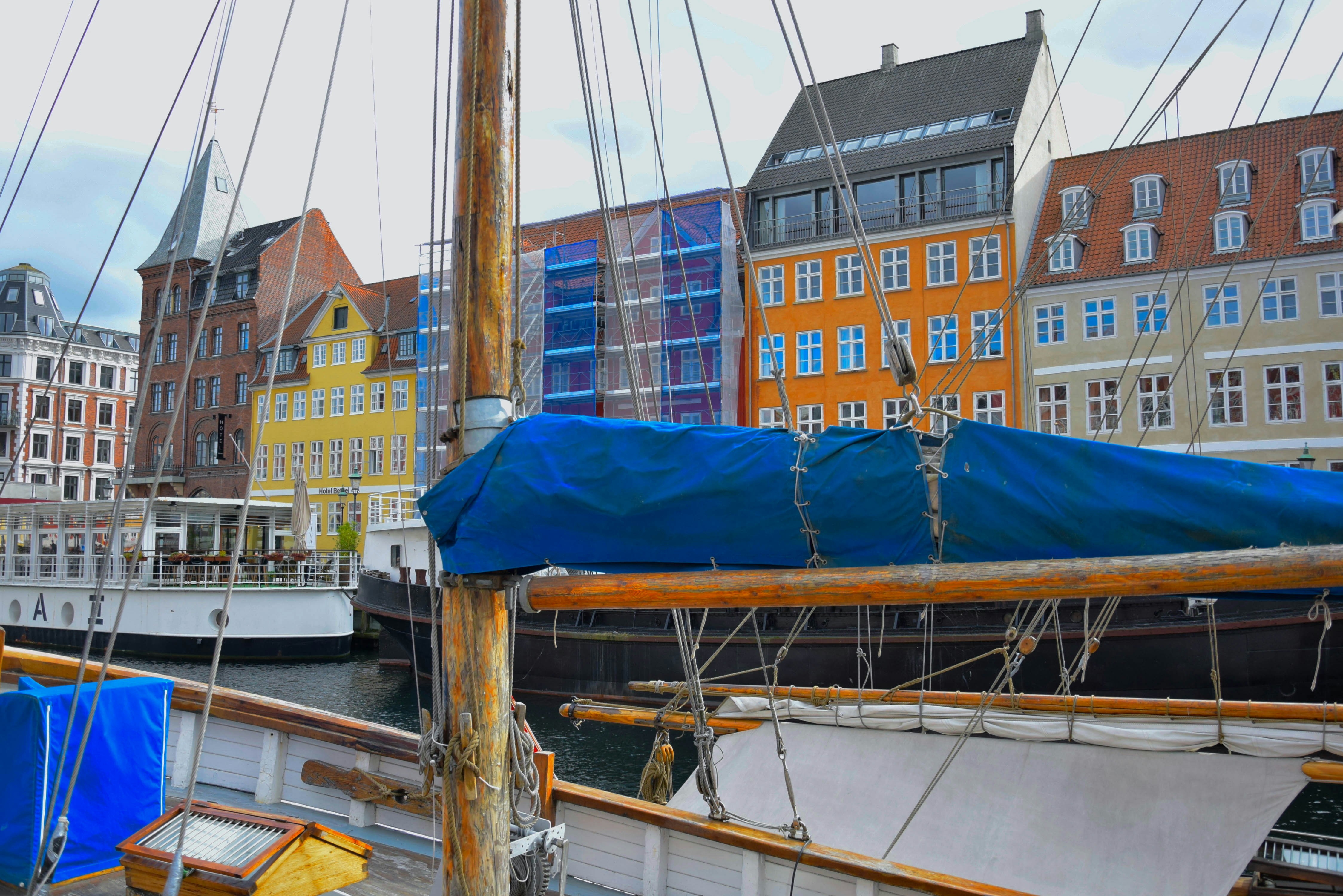 Masted Quiet in a Row: Colorful Harbor Homes Framed by a Sailboat
