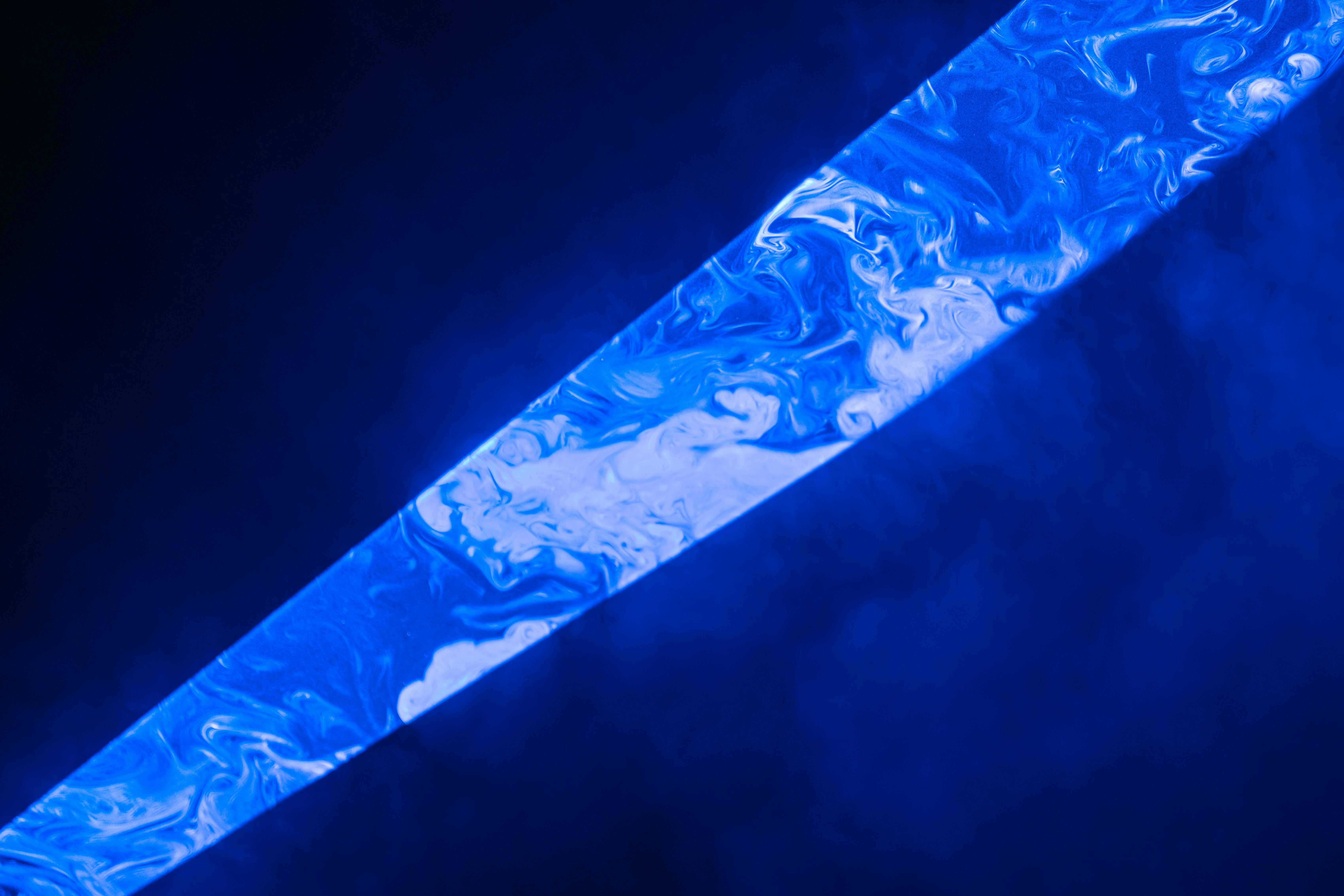Neon-Blue Marbled Ribbon Across Velvet Darkness