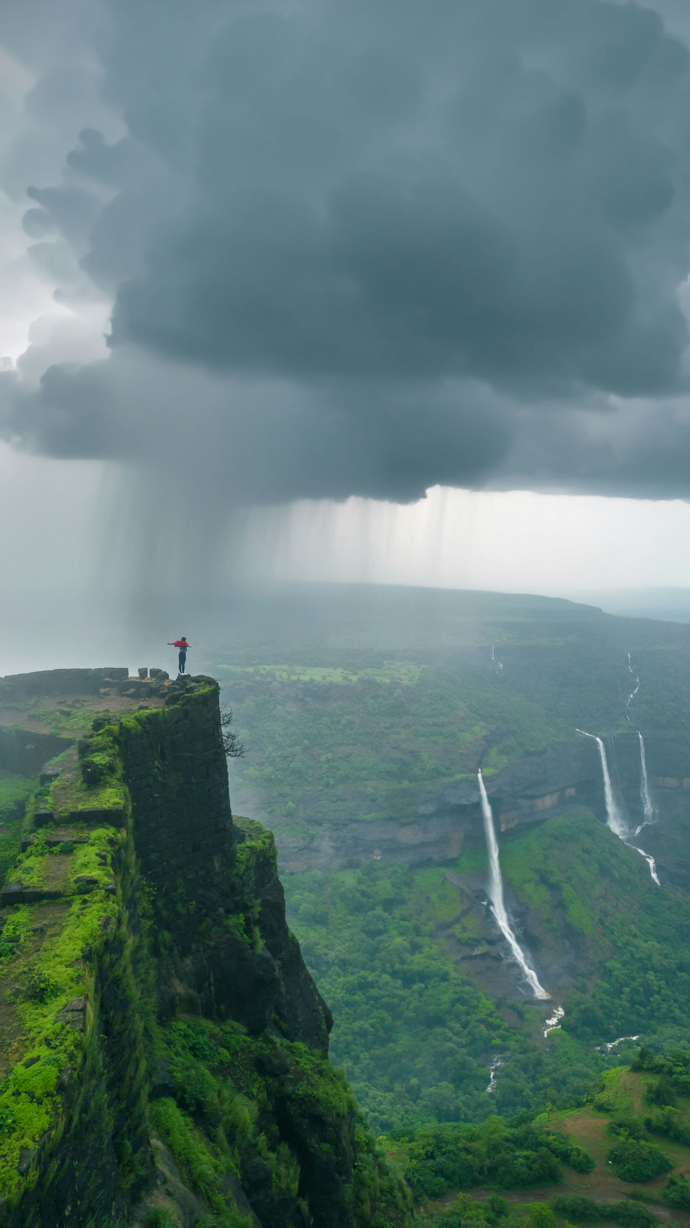 A person standing on top of a tall cliff photo – Free Outdoors Image on ...
