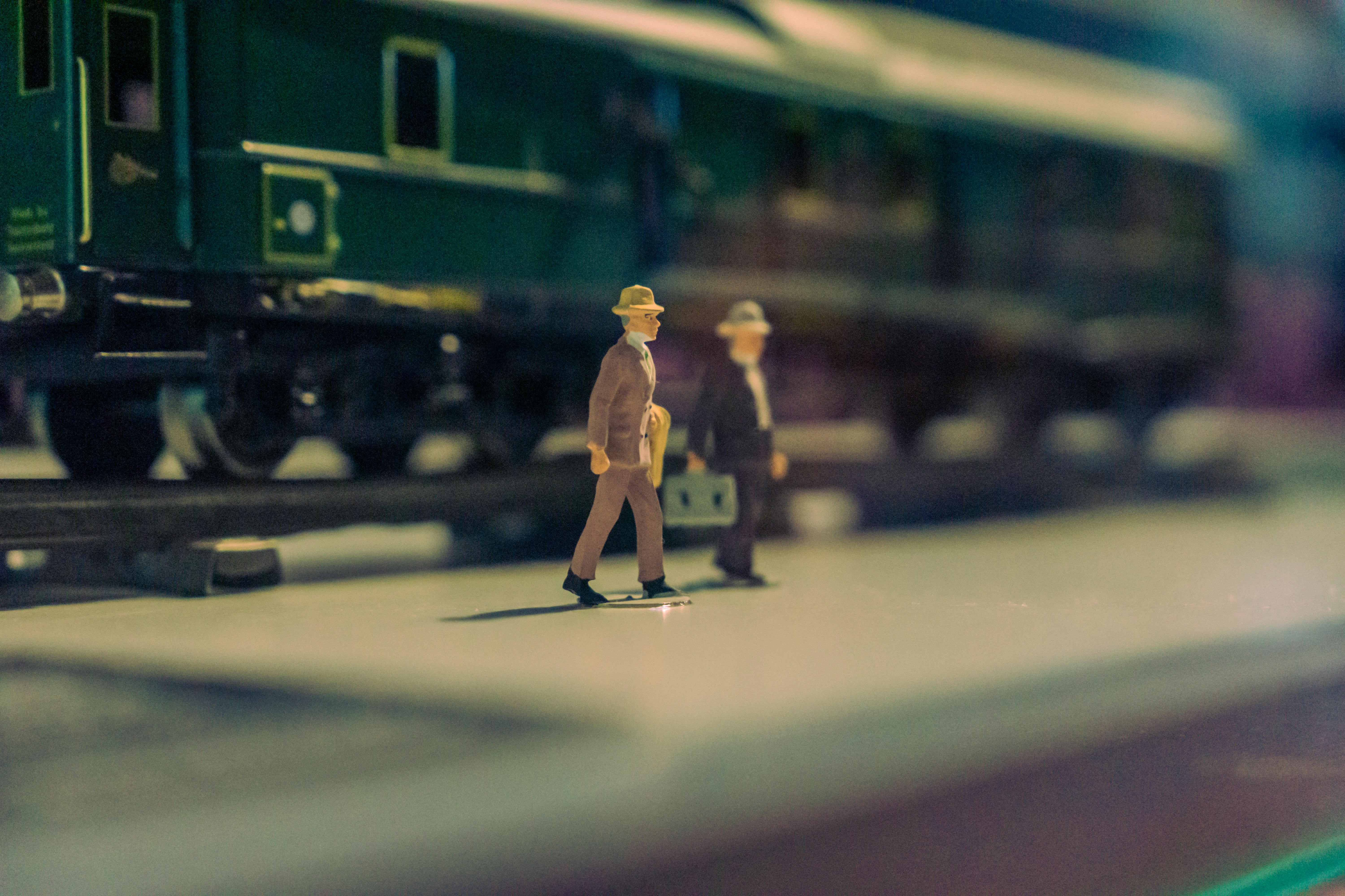 Miniature Trains, Big Moments: Two Figurines on a Sunset Platform
