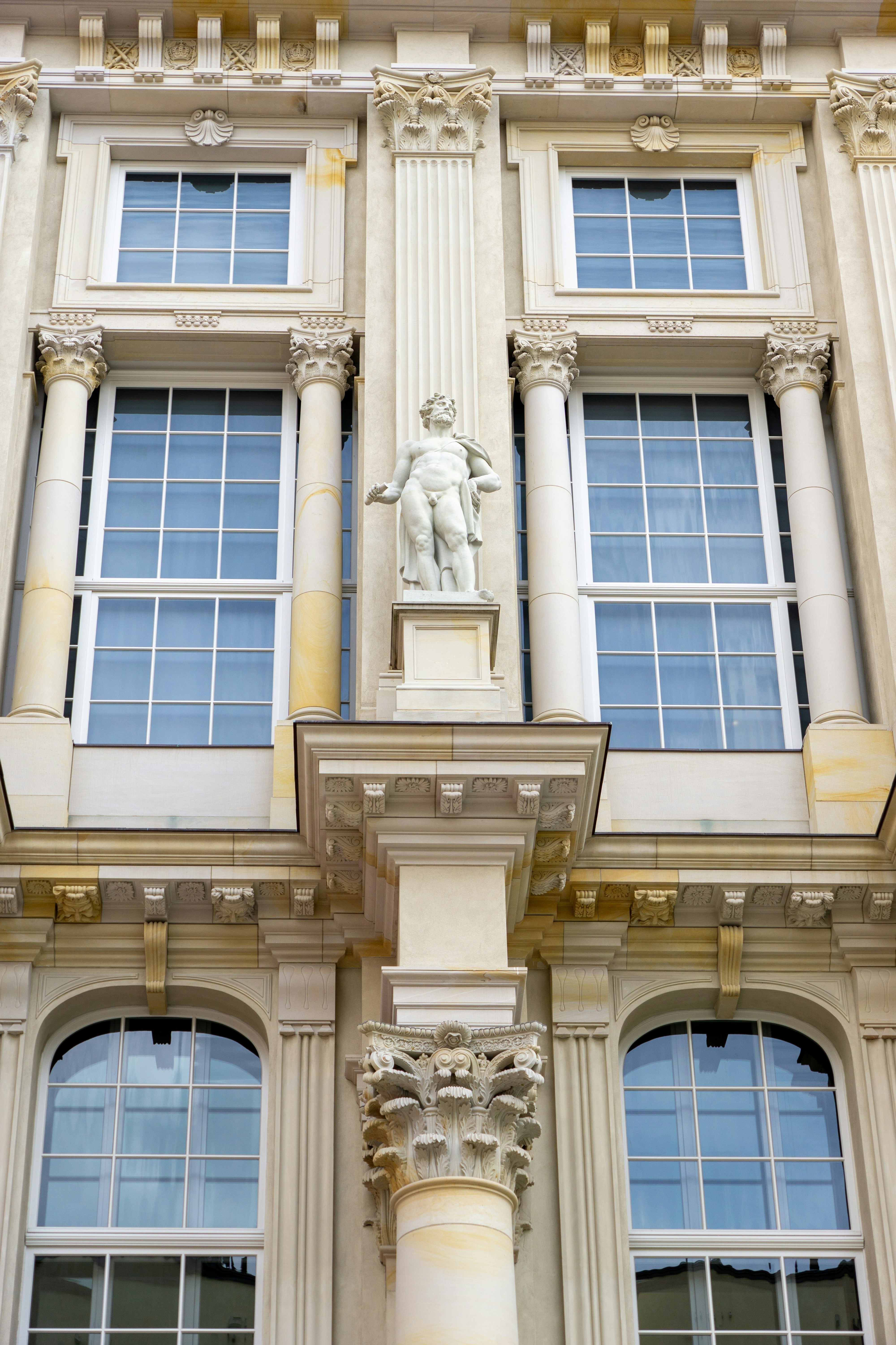 Central Statue Amid Neoclassical Facade: A Symmetry in Stone