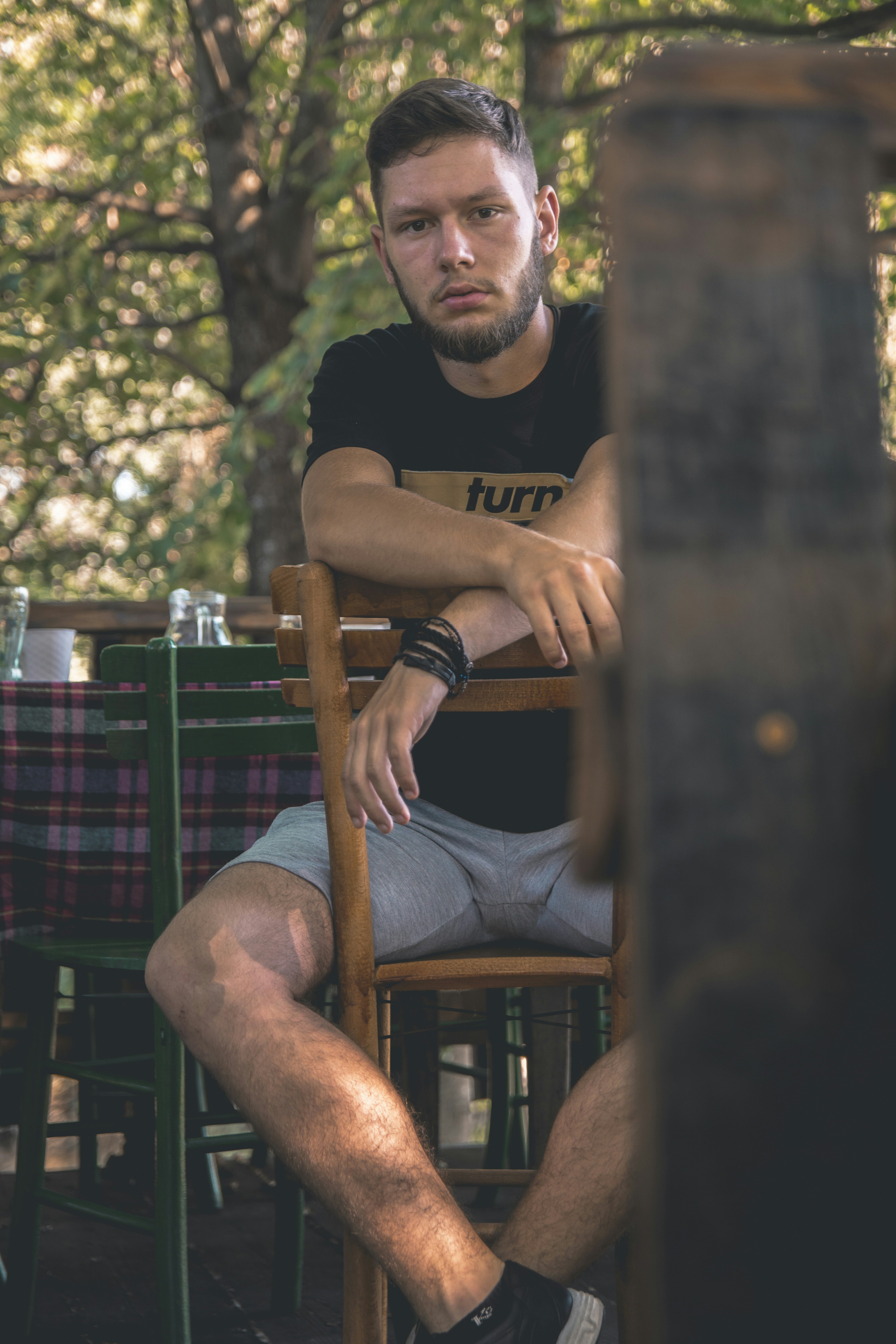 Dappled Light, Steady Gaze: Portrait on a Woodland Café Patio