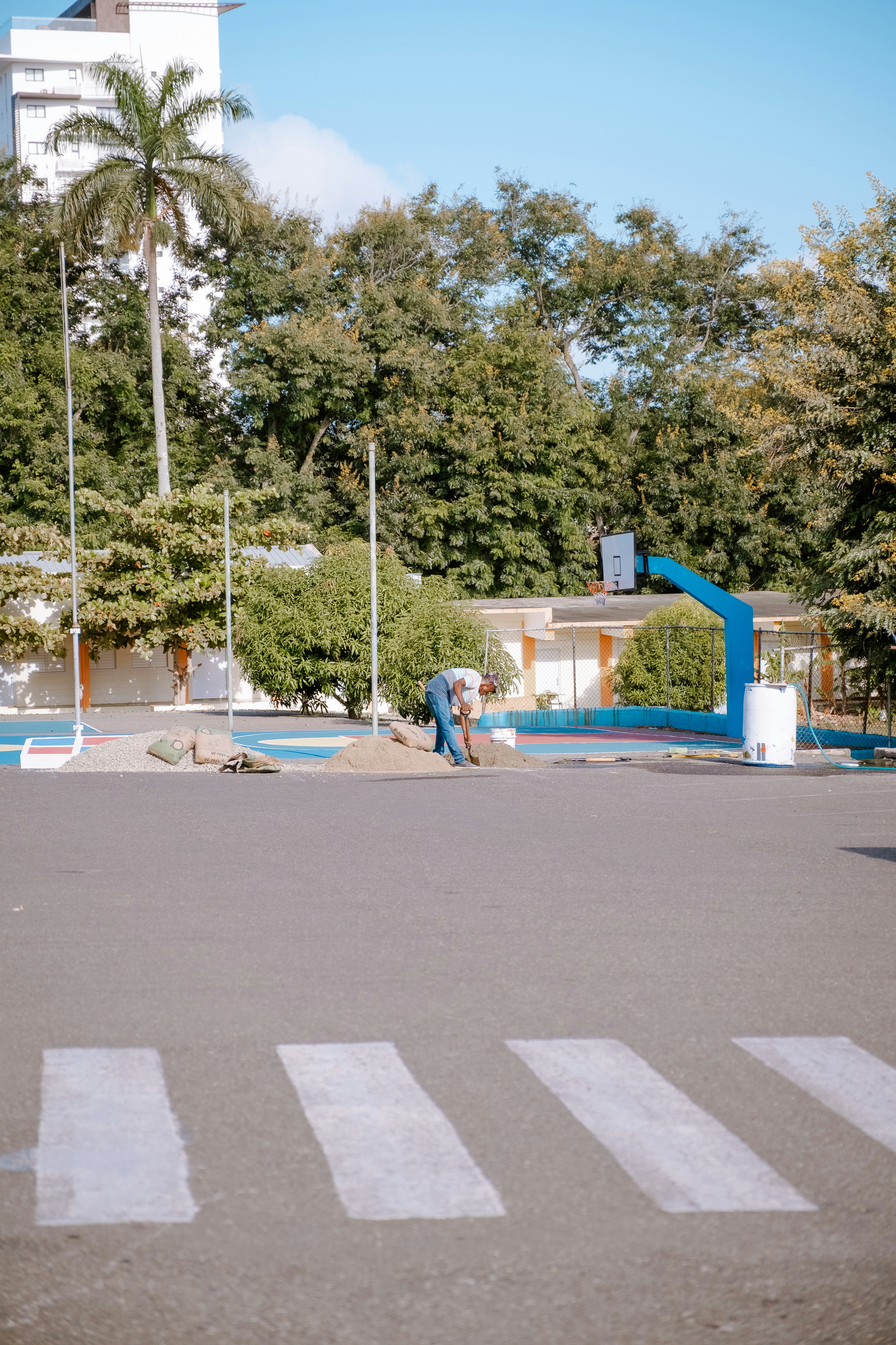 Blue Arc Over a Quiet Plaza: A Worker at Ground-Level Redevelopment